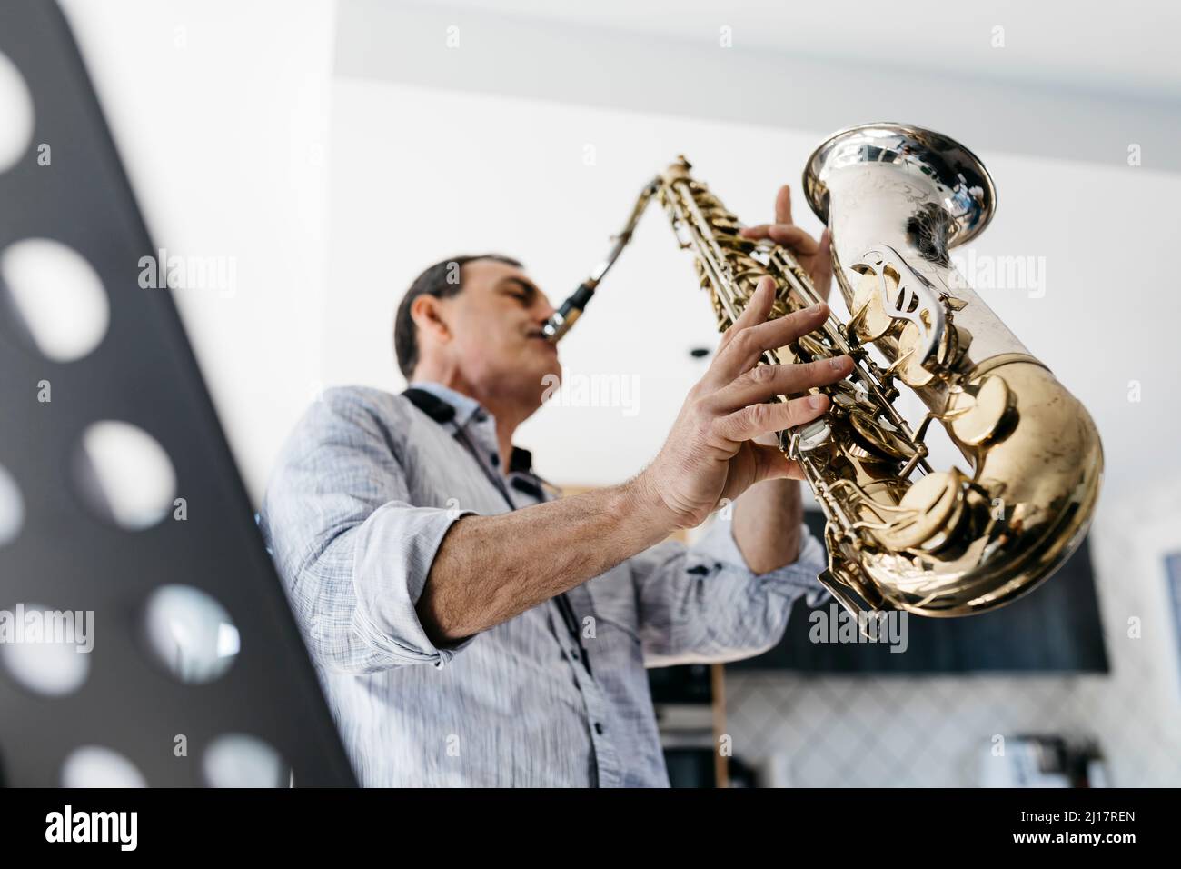 Saxophonist playing saxophone practicing at home Stock Photo - Alamy