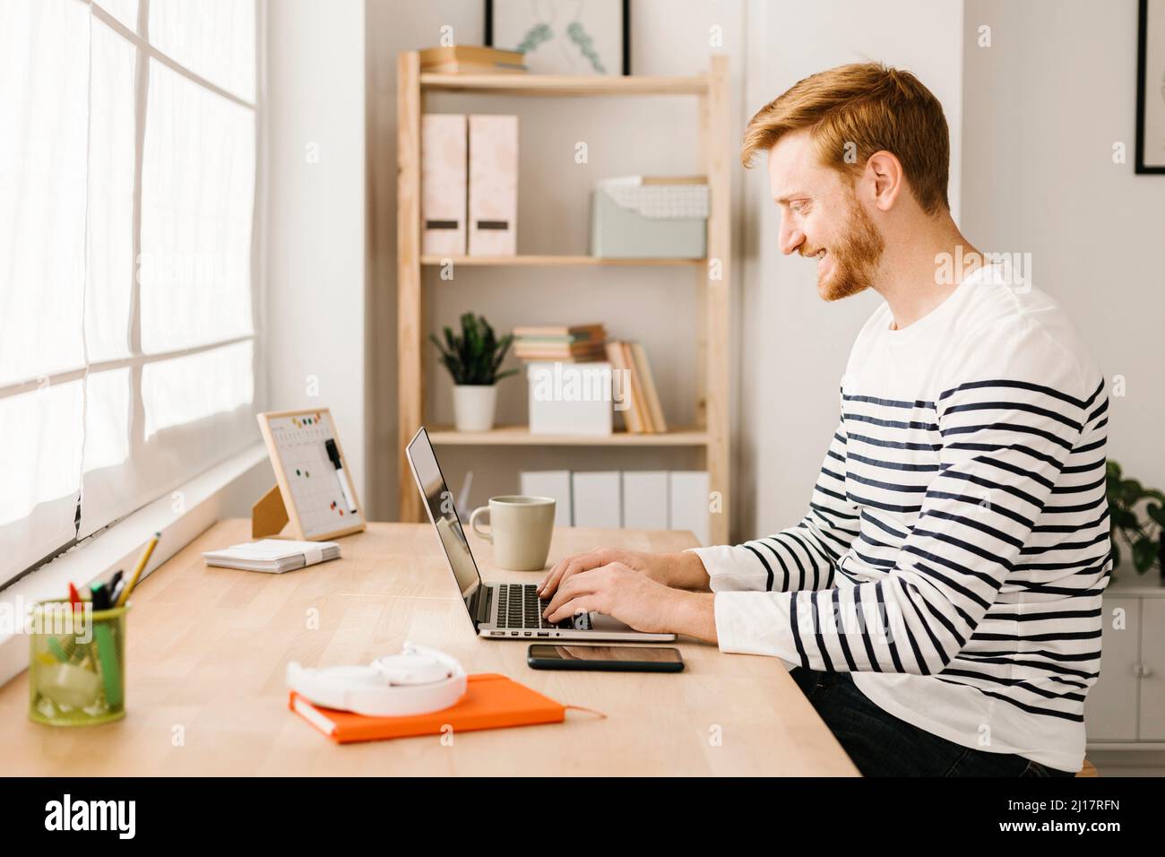Man smiling typing laptop hi-res stock photography and images - Alamy