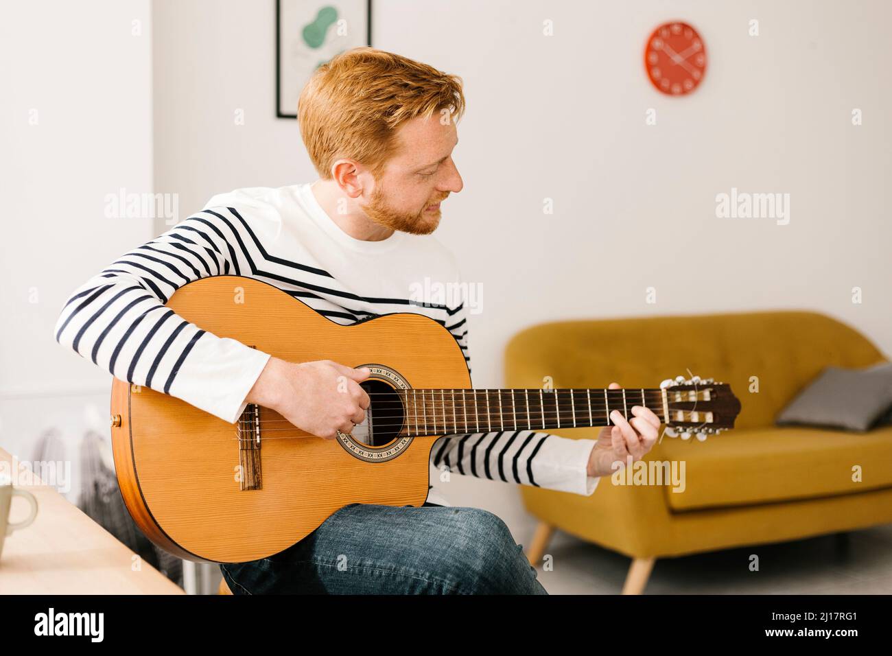 Young man practicing guitar in living room at home Stock Photo - Alamy