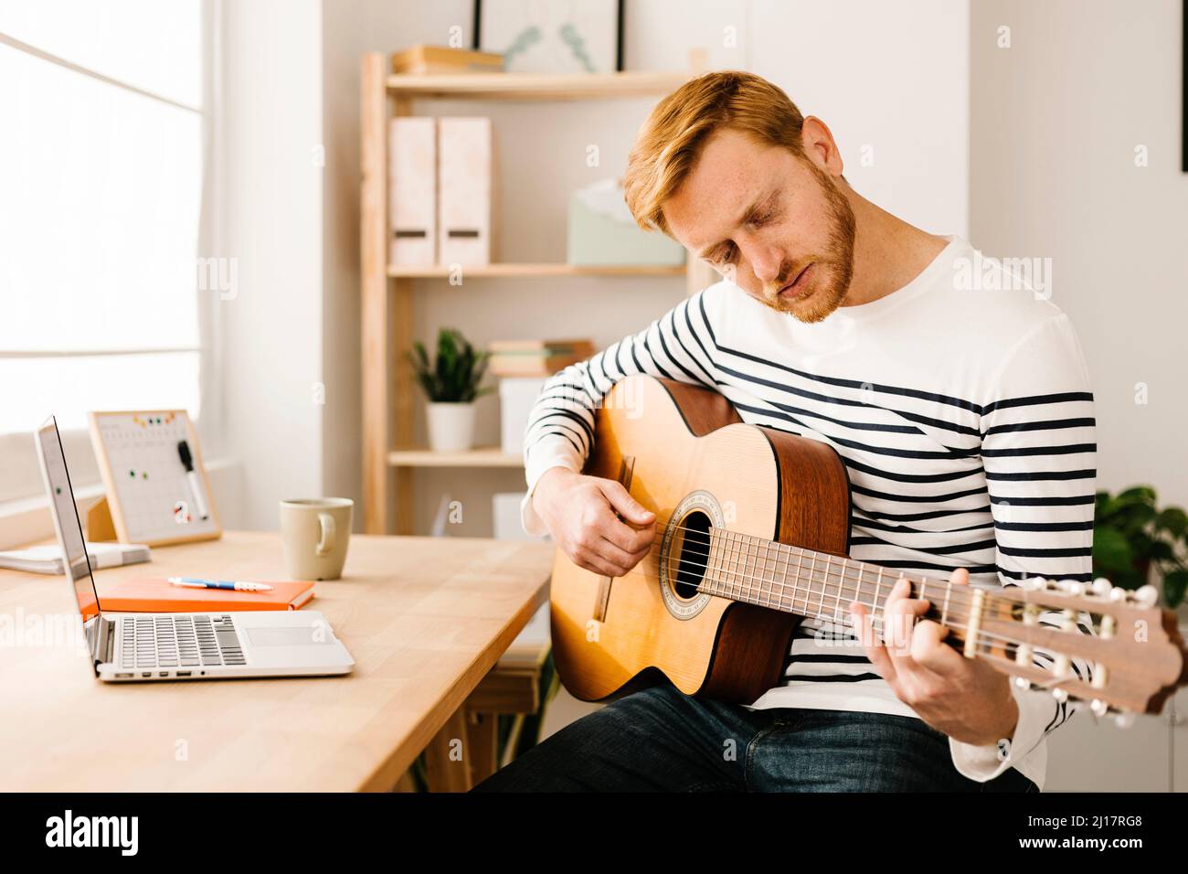 Man sitting practicing guitar hi-res stock photography and images - Alamy