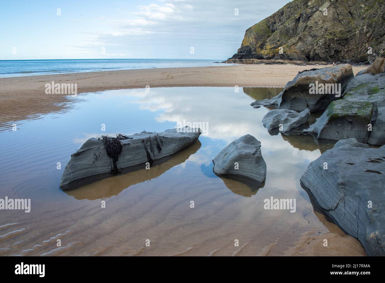 Colour photograph of coastal stones on beach smoothed and rounded by ...