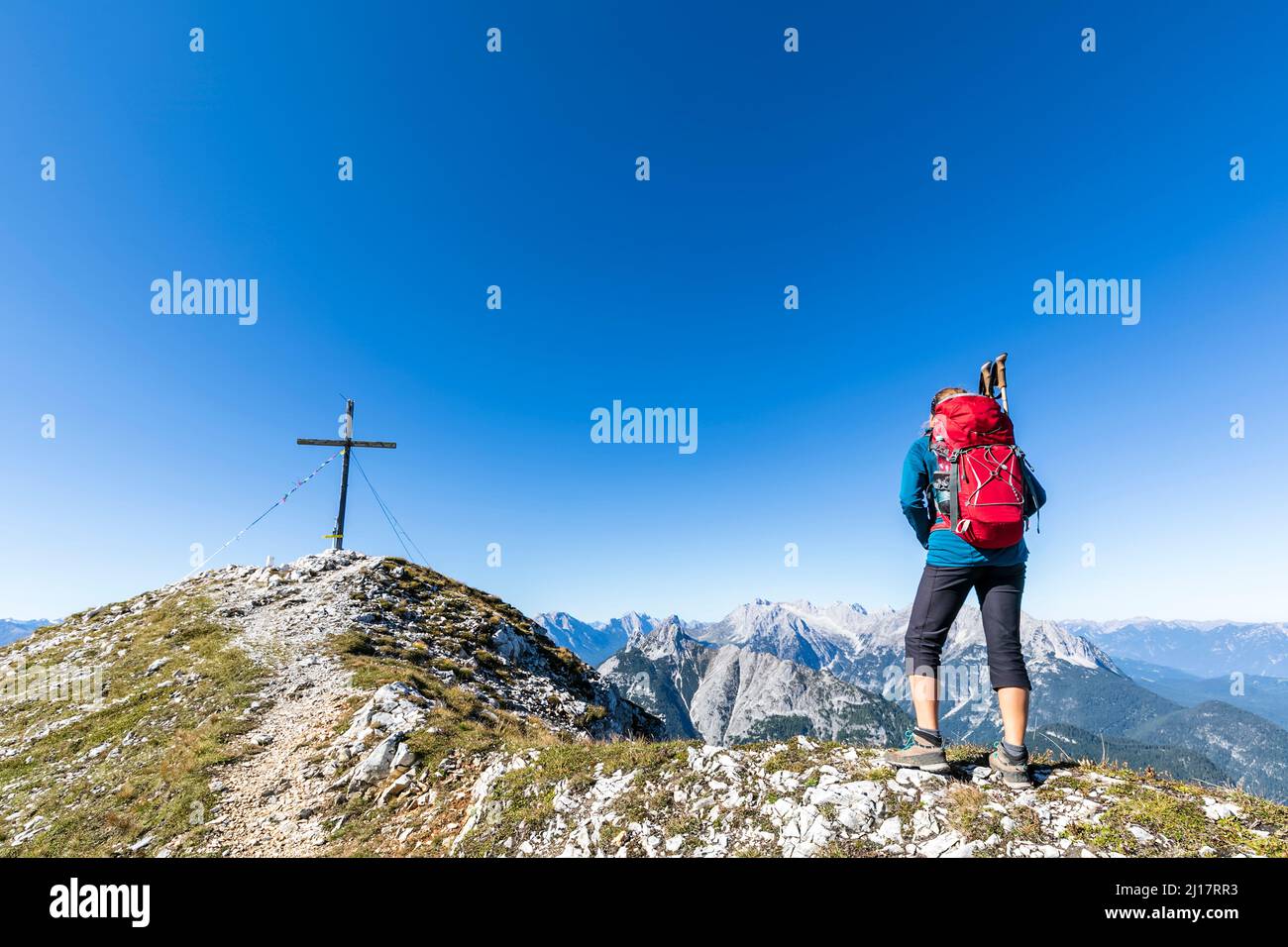 Female hiker looking at summit cross of Brunnensteinspitze Stock Photo ...