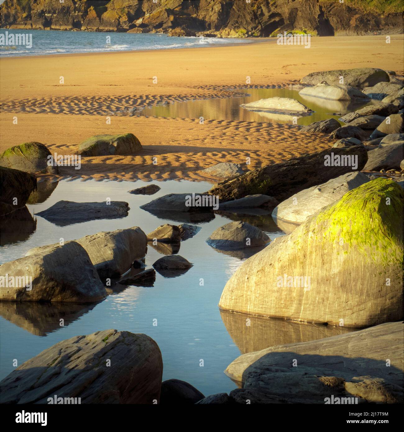 Colour photograph of coastal rocks and tidal pools on beach some ...