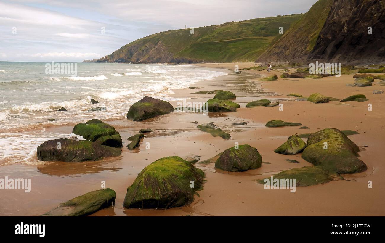 Colour photograph of coastal rocks on beach some smoothed and rounded ...