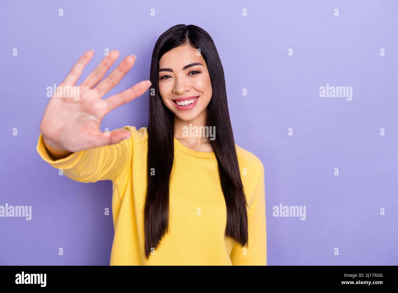 Portrait of dreamy smiling female showing you hand high five say hello ...