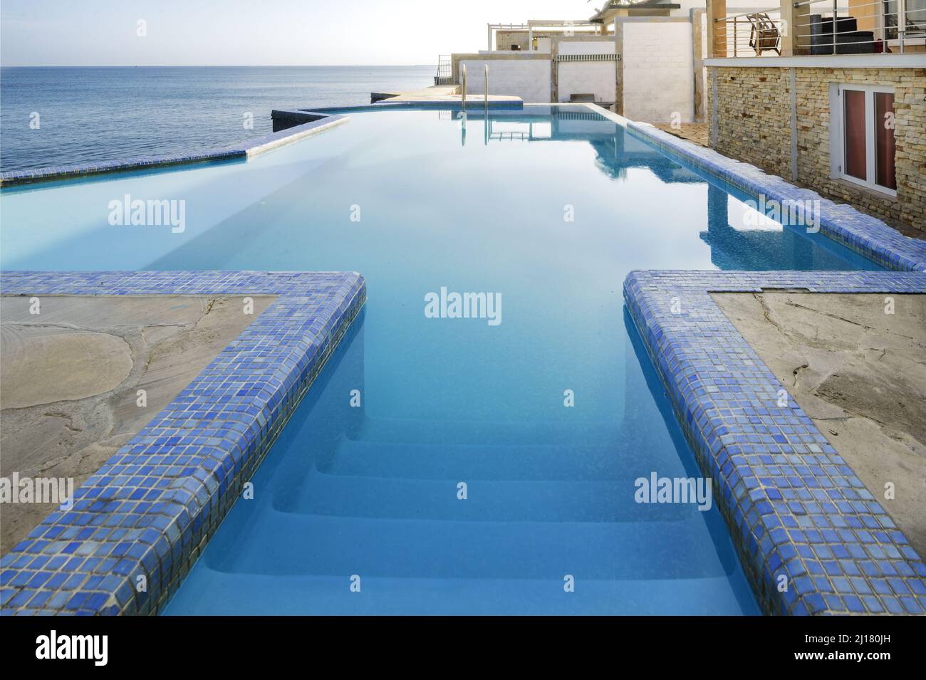steps to get into the pool with the sea background Stock Photo - Alamy