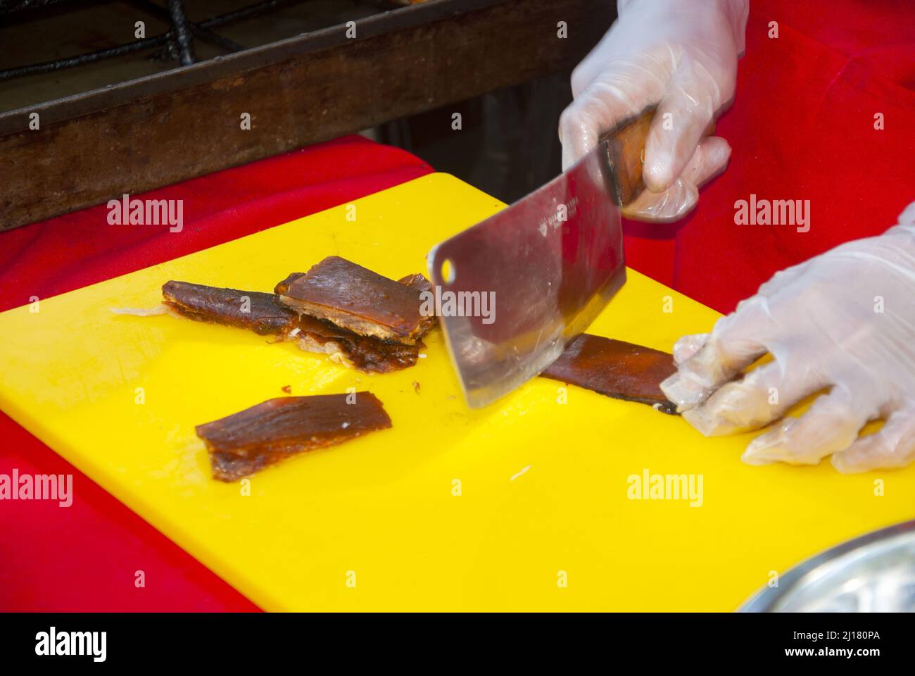 Pork cut, worker with latex gloves, preparing food in Latin America ...