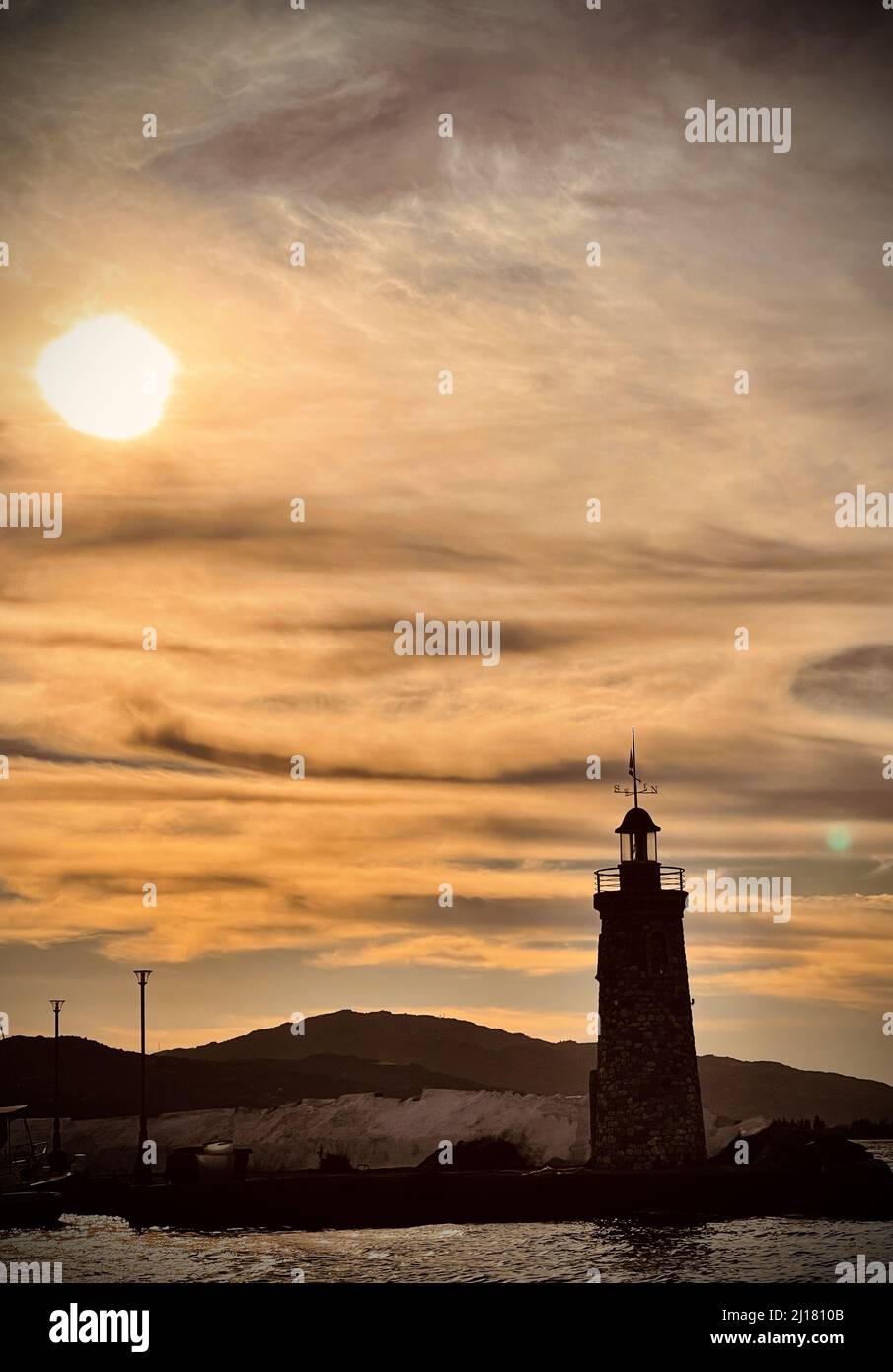 The vertical shot of a lighthouse silhouette and a blurred yellow ...