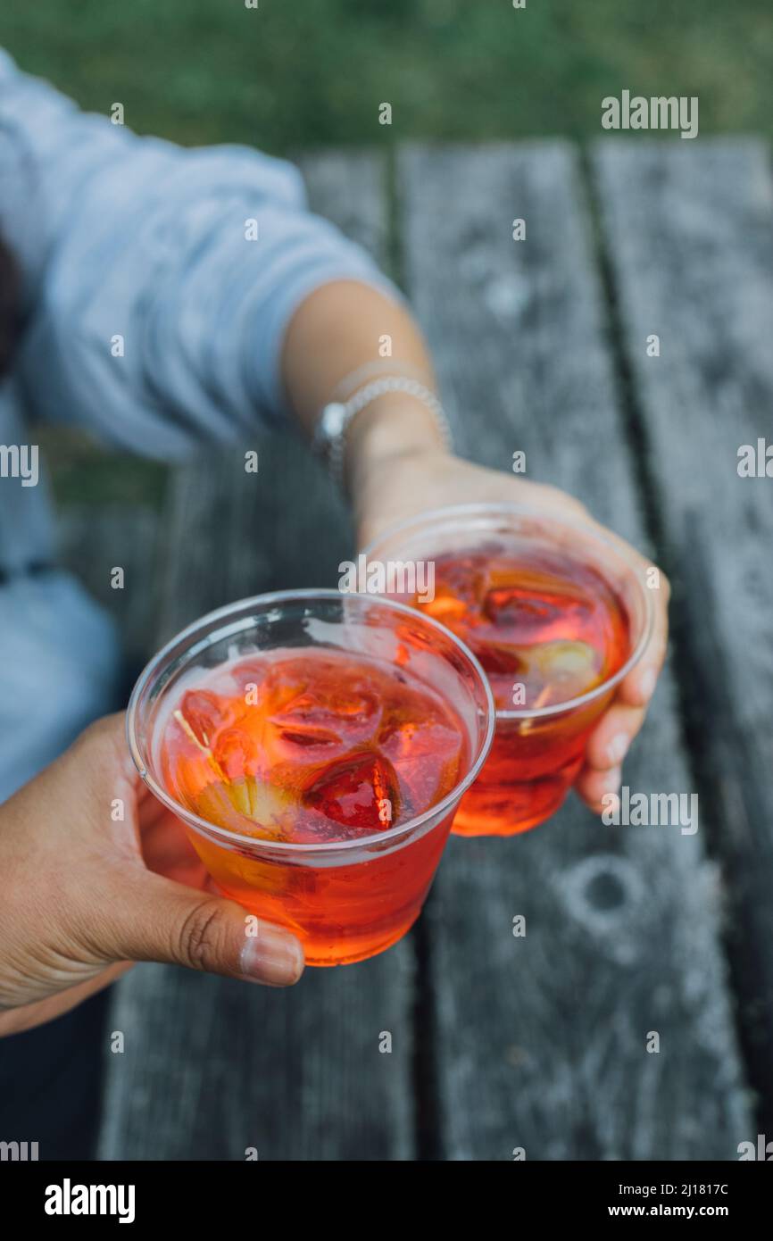 cheers with two aperol spritz cocktails in plastic cups Stock Photo - Alamy