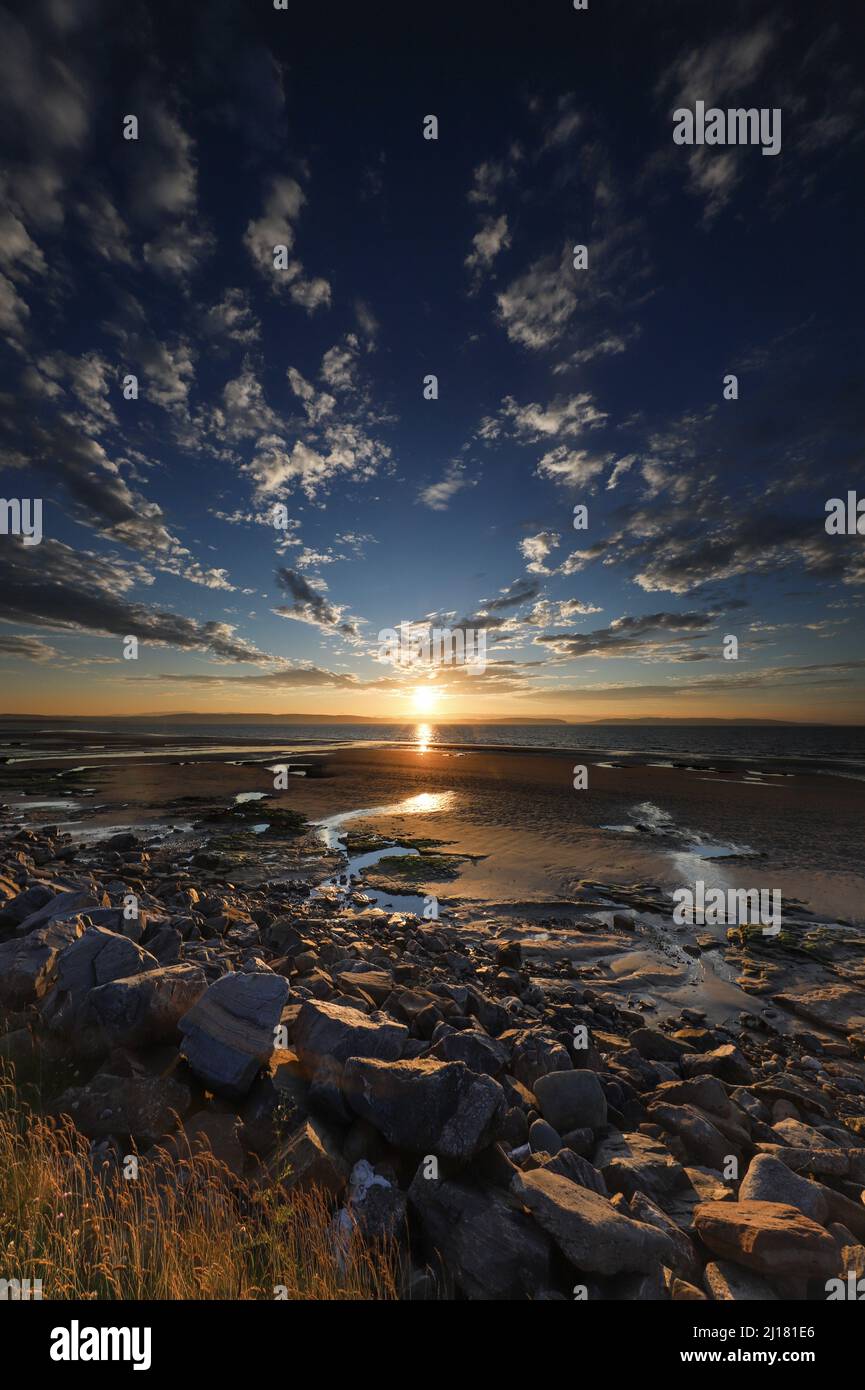 Sun setting on beach with spectacular light Stock Photo - Alamy