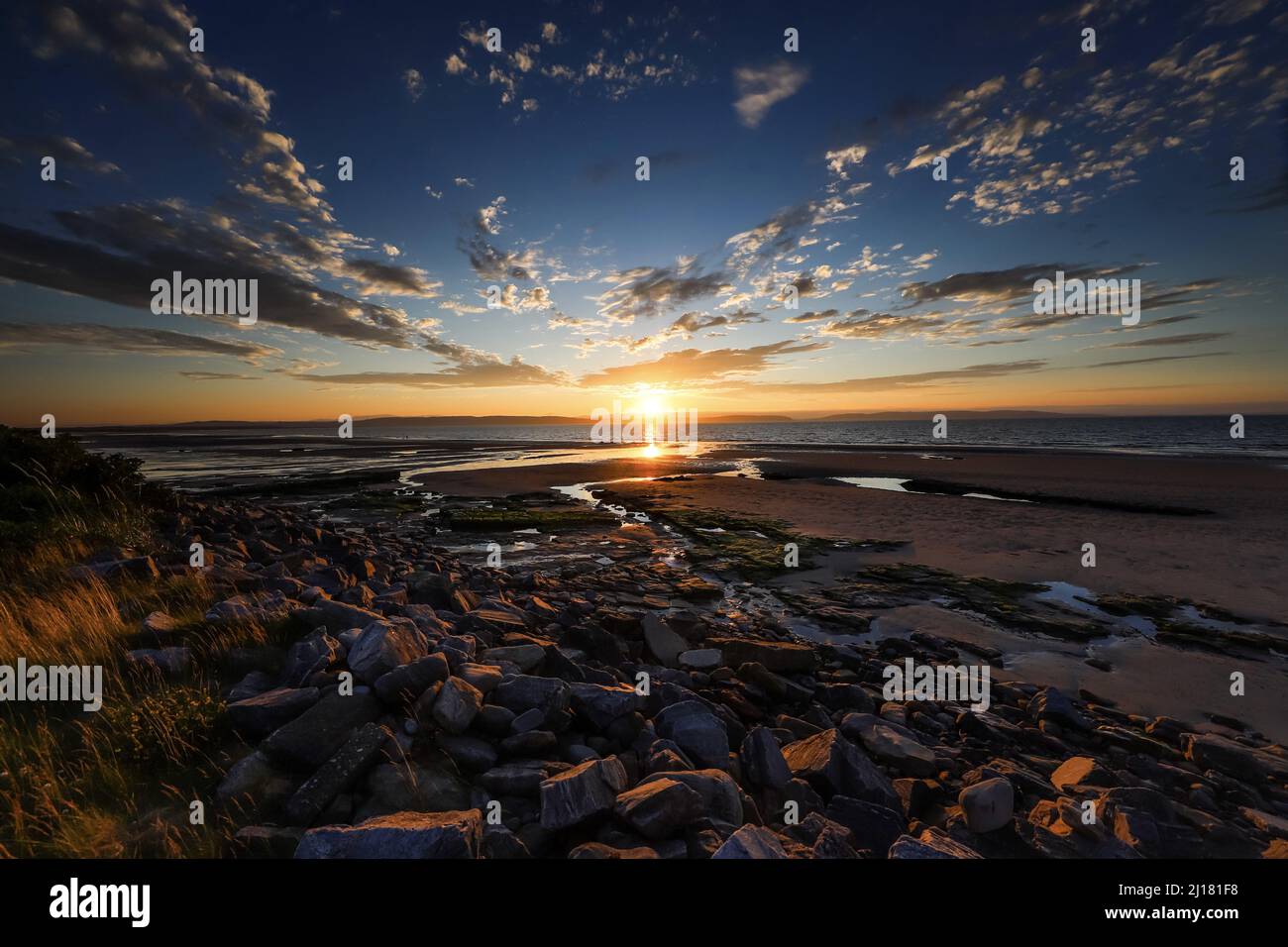 Sun setting on a beach Stock Photo - Alamy