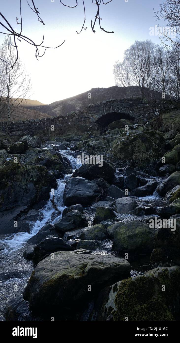 A vertical shot of arched bridge over the river Stock Photo - Alamy