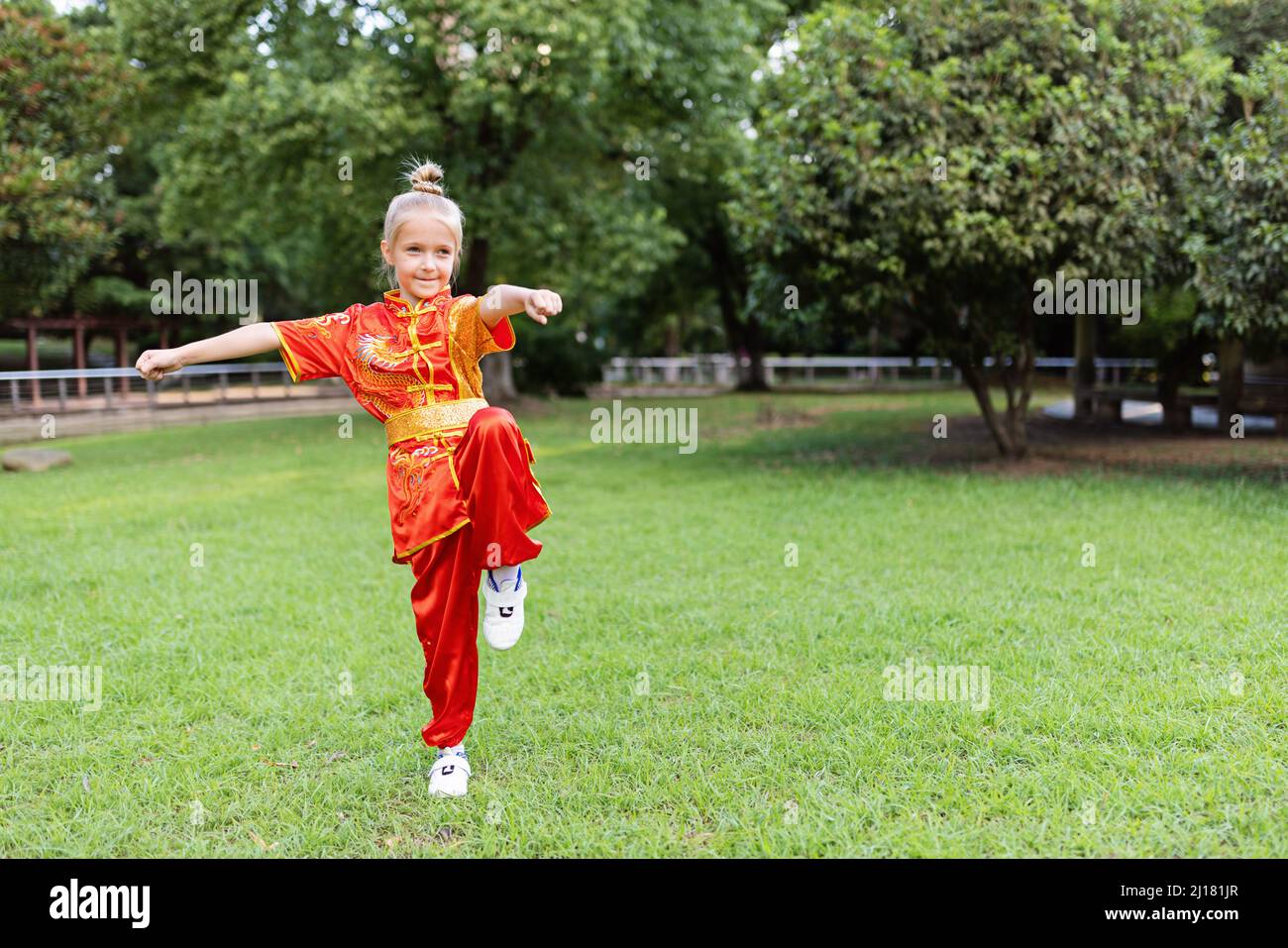 Cute little caucasian girl seven years old in red sport wushu uniform ...