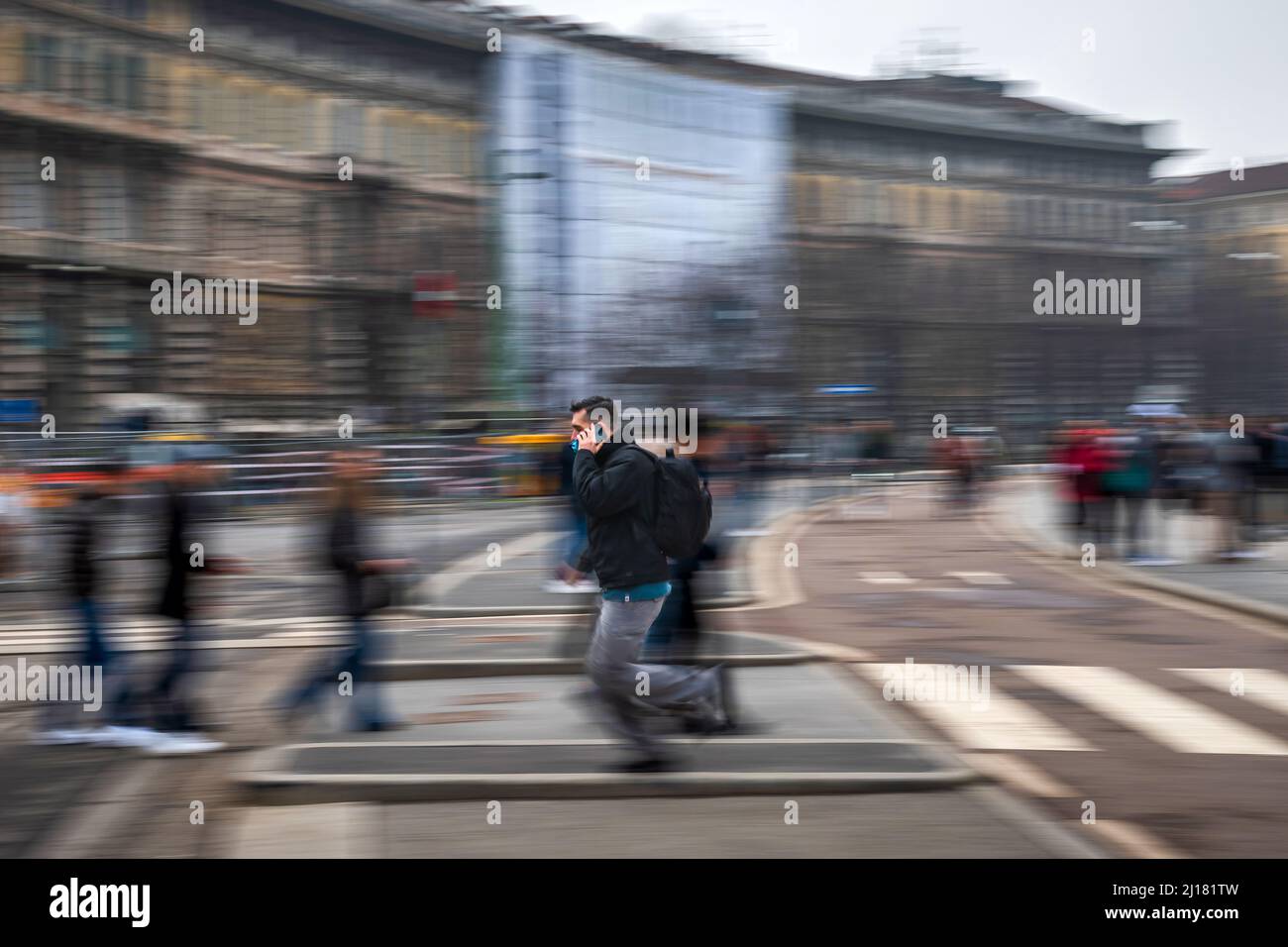 A beautiful shot of a man running fast in haste while on the phone ...