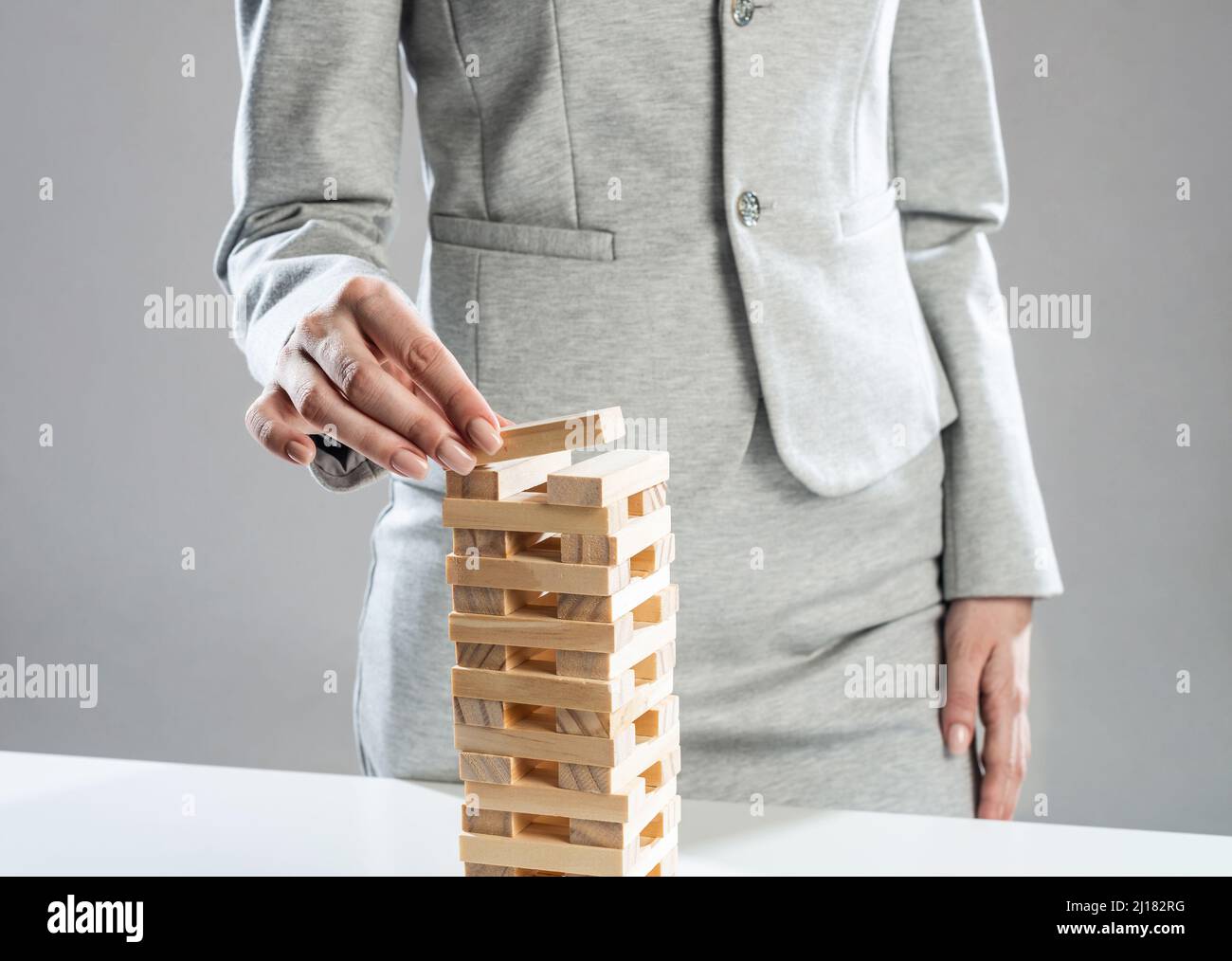 Business woman building tower from wooden blocks Stock Photo - Alamy