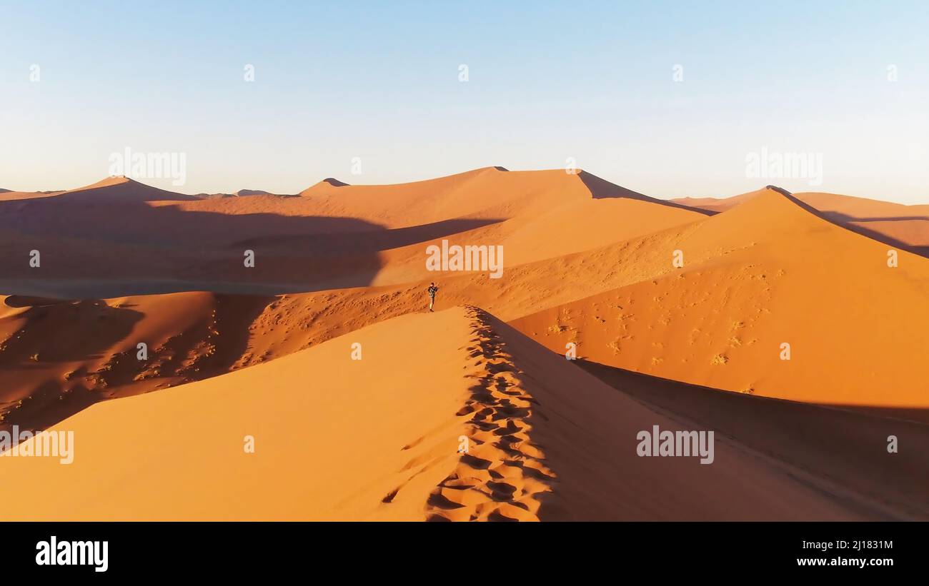 An aerial shot of a beautiful orange namibian sand dunes on a sunset ...