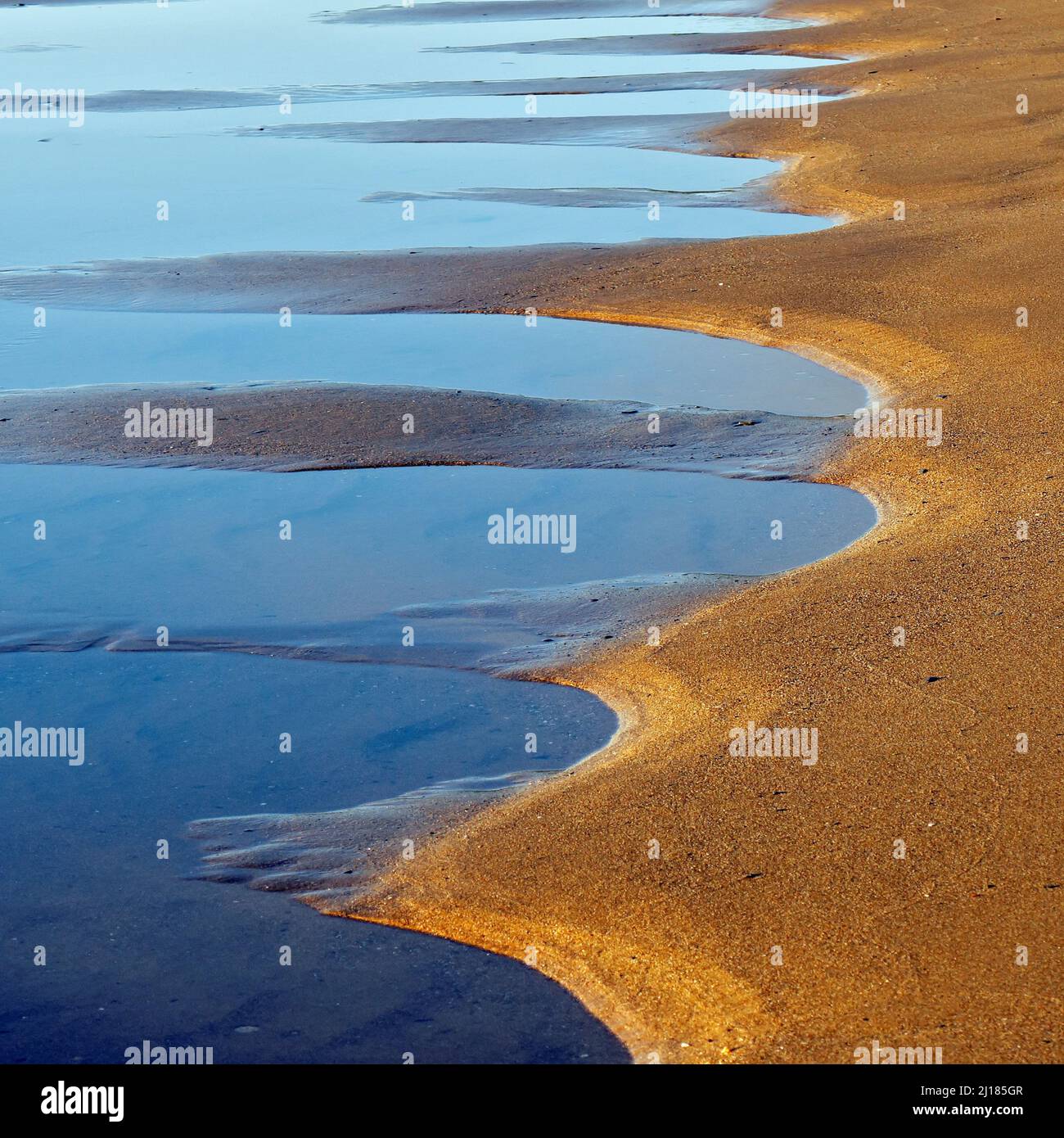 Abstract detailed tidal patterns in the sand at low tide on Penbryn ...