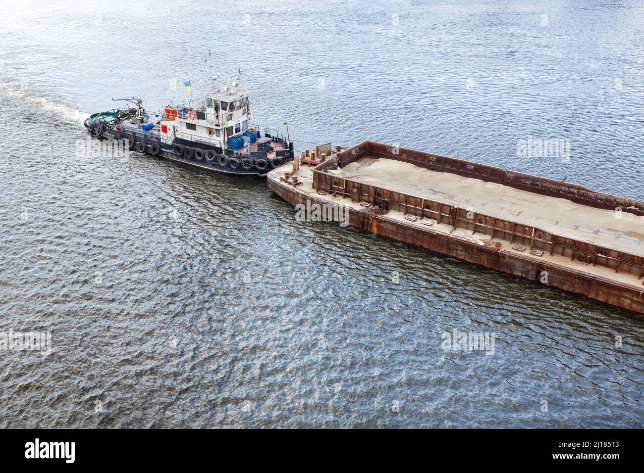 An old river tug pushes an empty rusty barge down the river Stock Photo ...