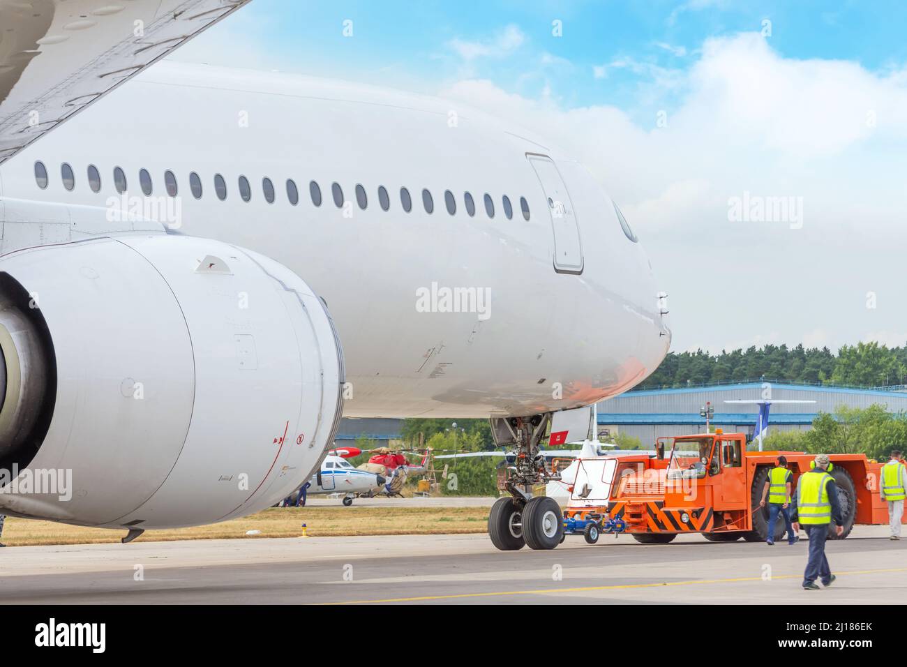 Pushback truck is towing the aircraft to a parking lot Stock Photo - Alamy