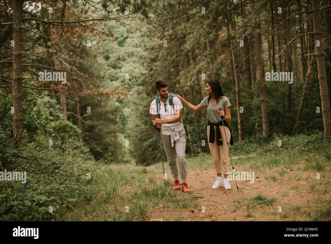 Couple of young hikers with backpacks walk through the forest Stock ...