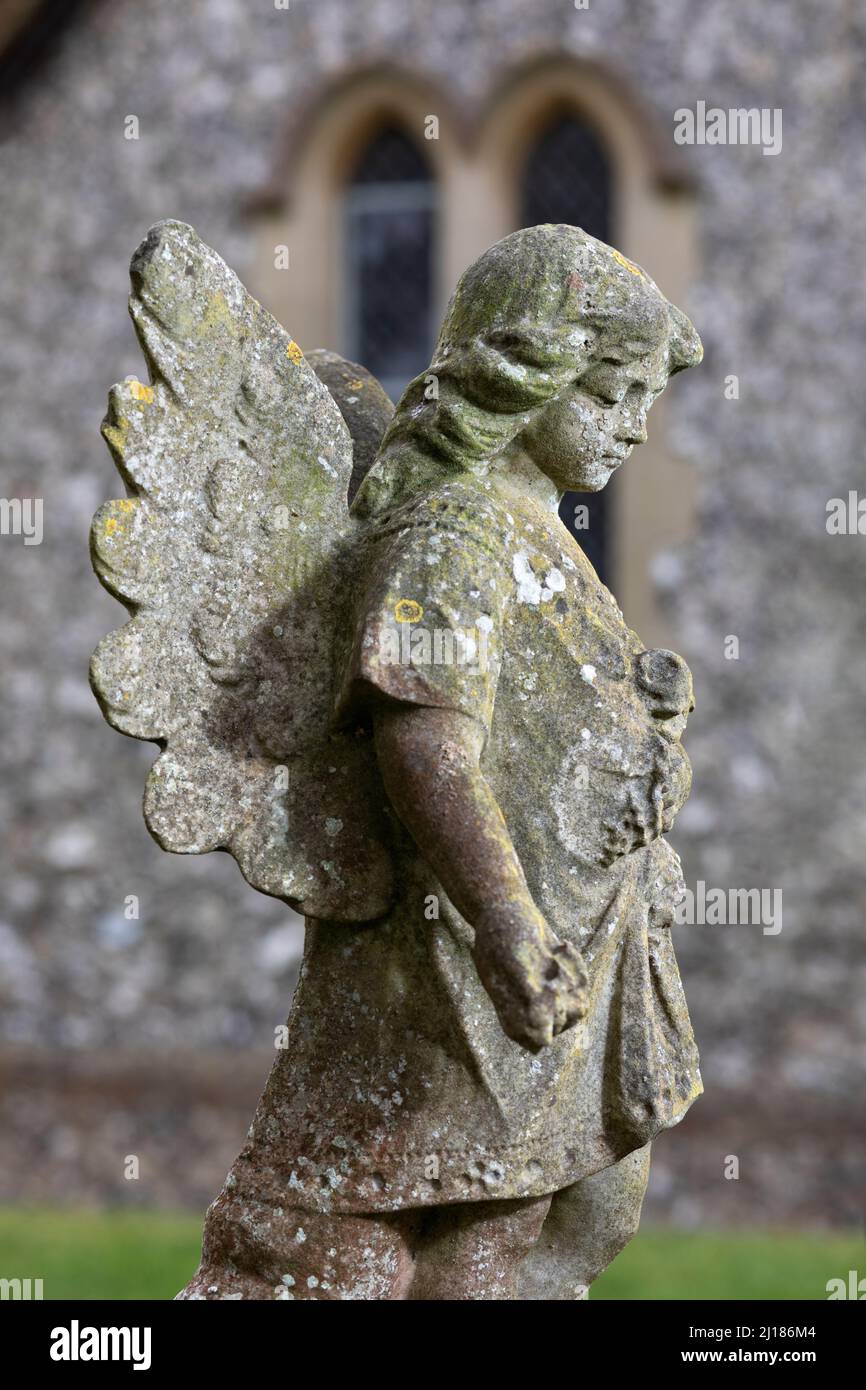 Stone carved angel with wings outside flint-stone church, Berkshire ...