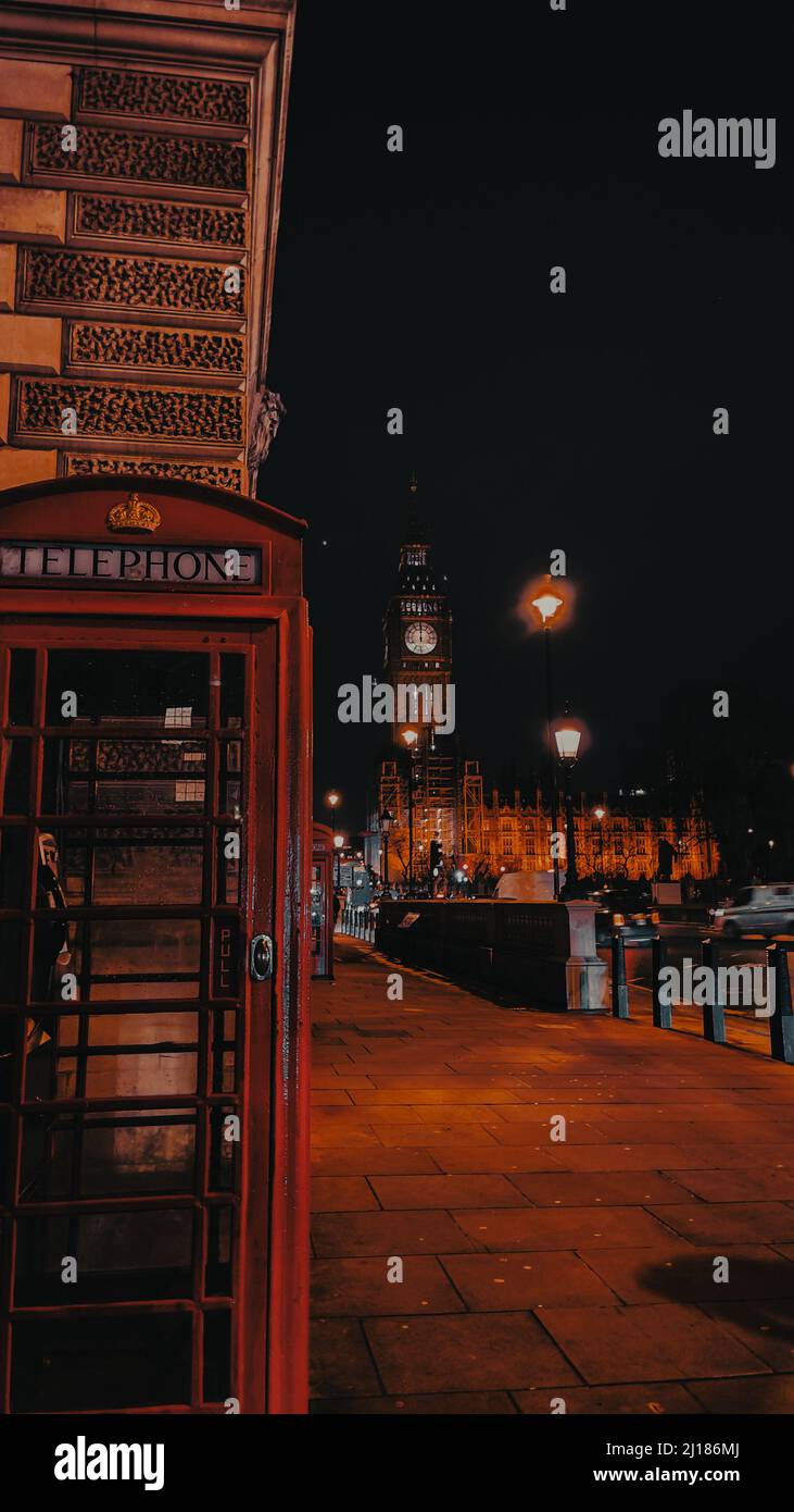 The vertical shot of a red phone box in London in the night Stock Photo ...