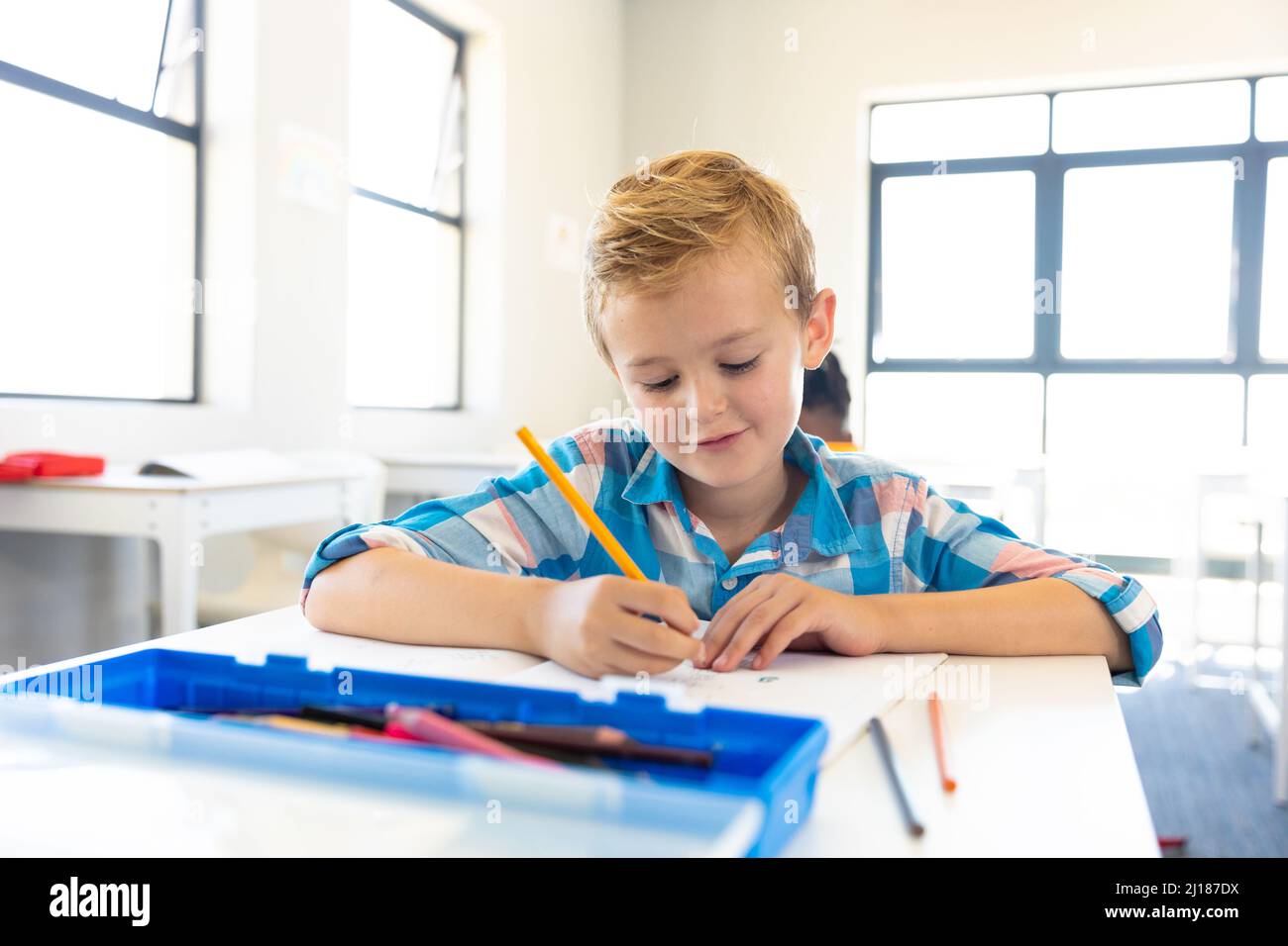 Young schoolboy sitting writing hi-res stock photography and images - Alamy