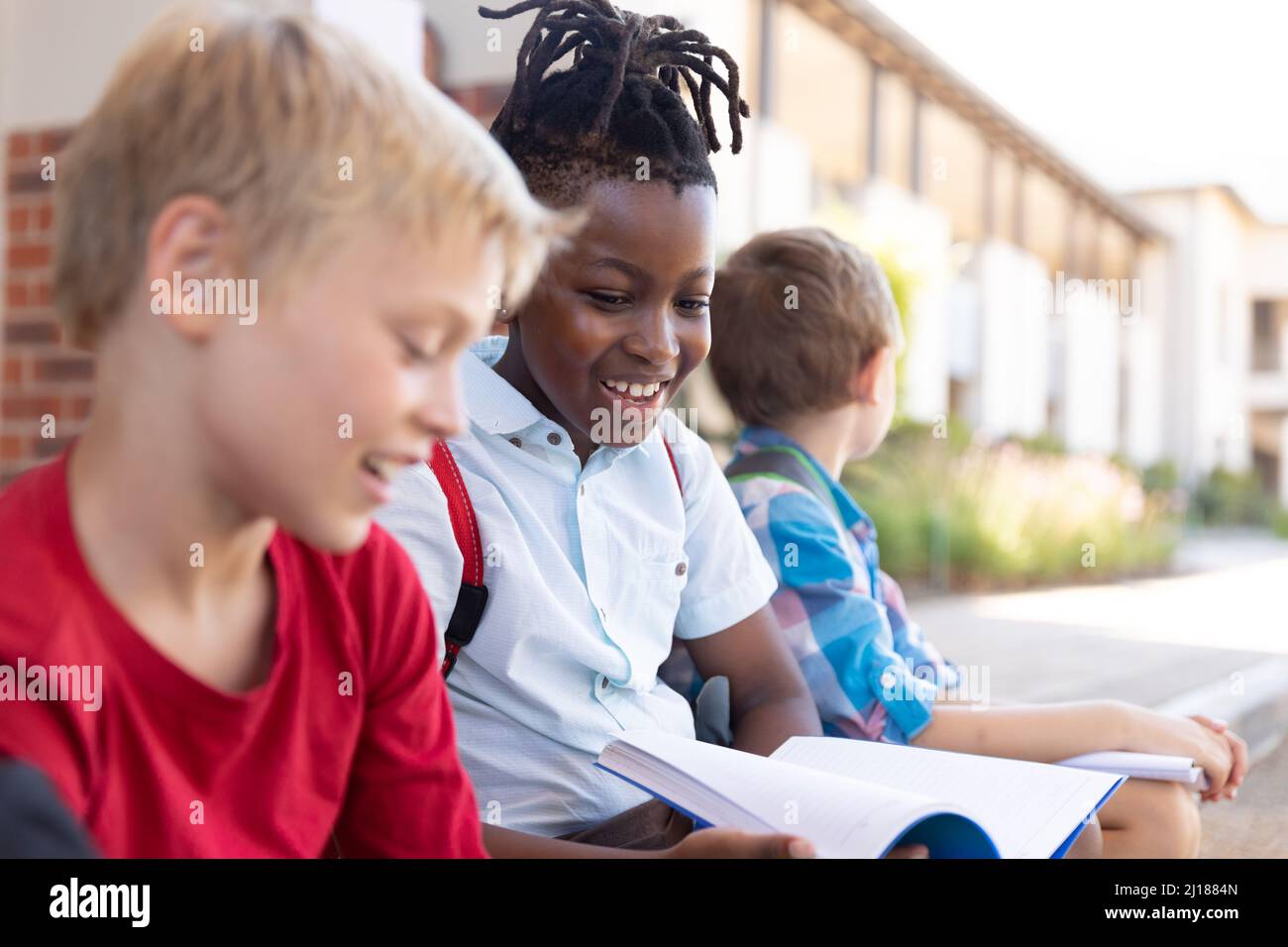 Smiling african american elementary schoolboy studying with caucasian ...