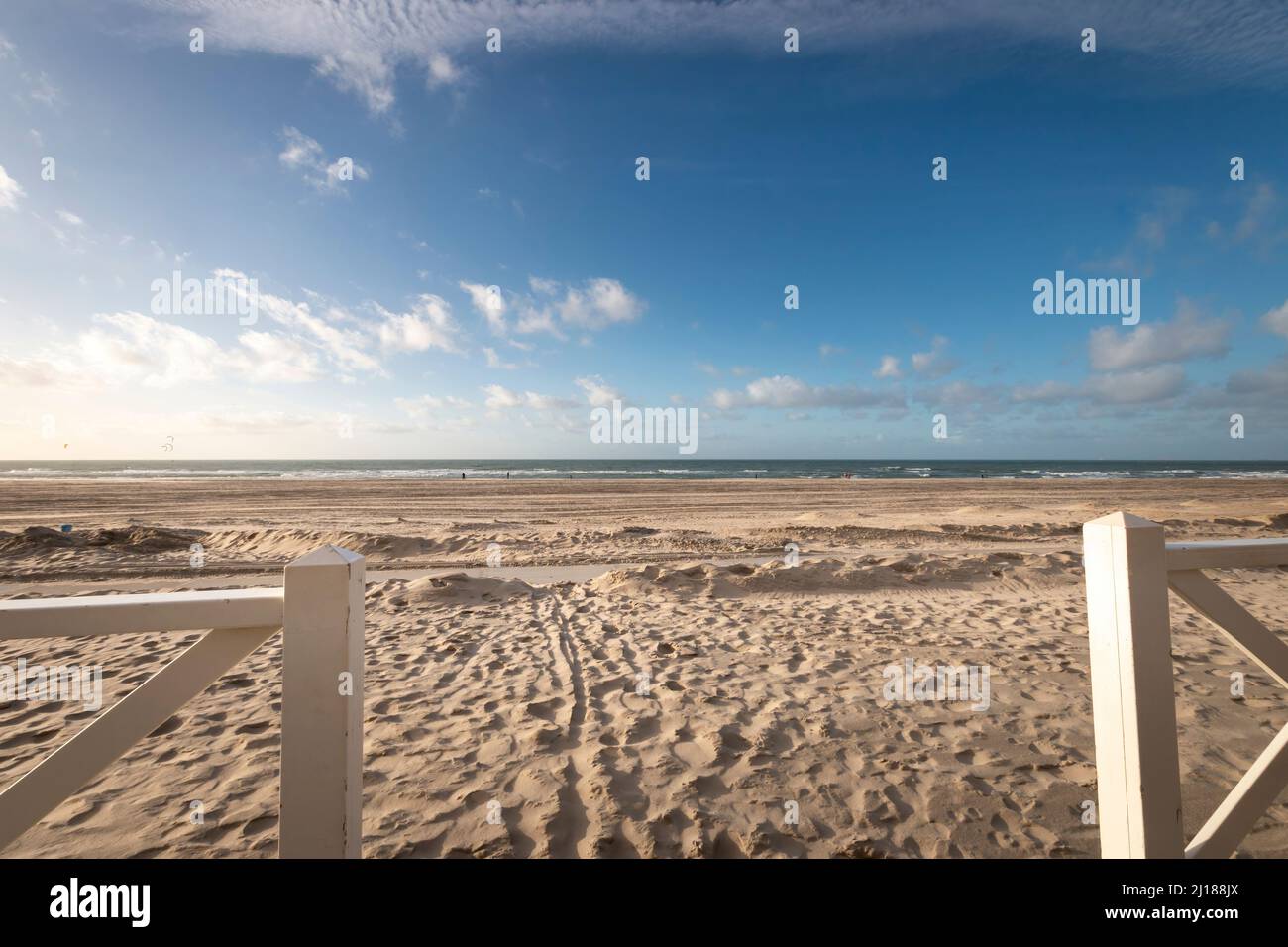 Scenic view of North Sea beach with railing of a beach hut against blue ...