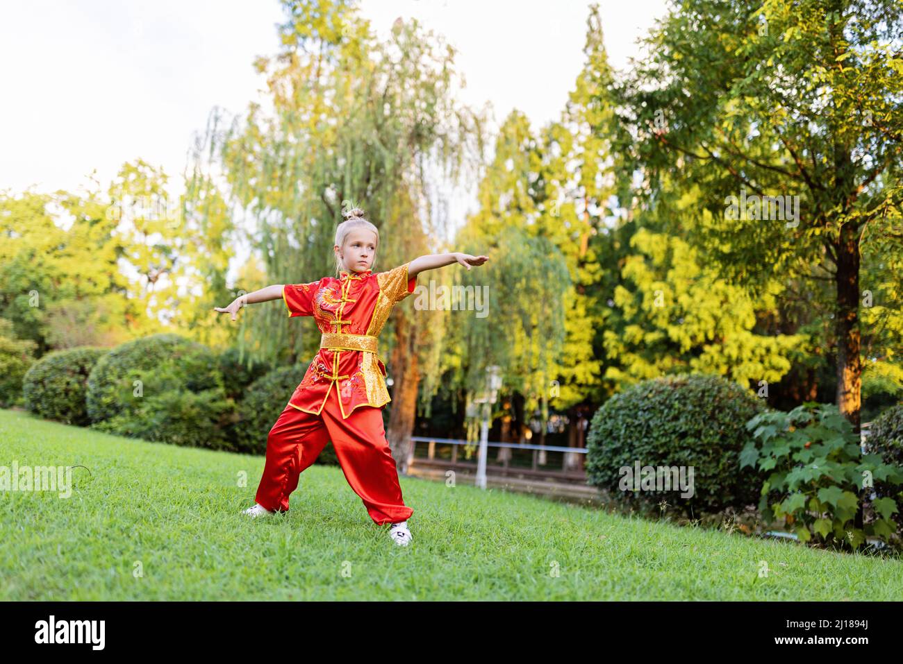 Cute little caucasian girl seven years old in red sport wushu uniform ...
