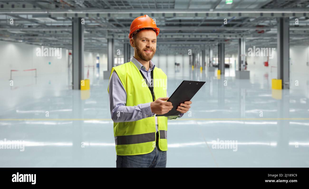 Engineer wearing a reflective vest and helmet holding a clipboard and ...