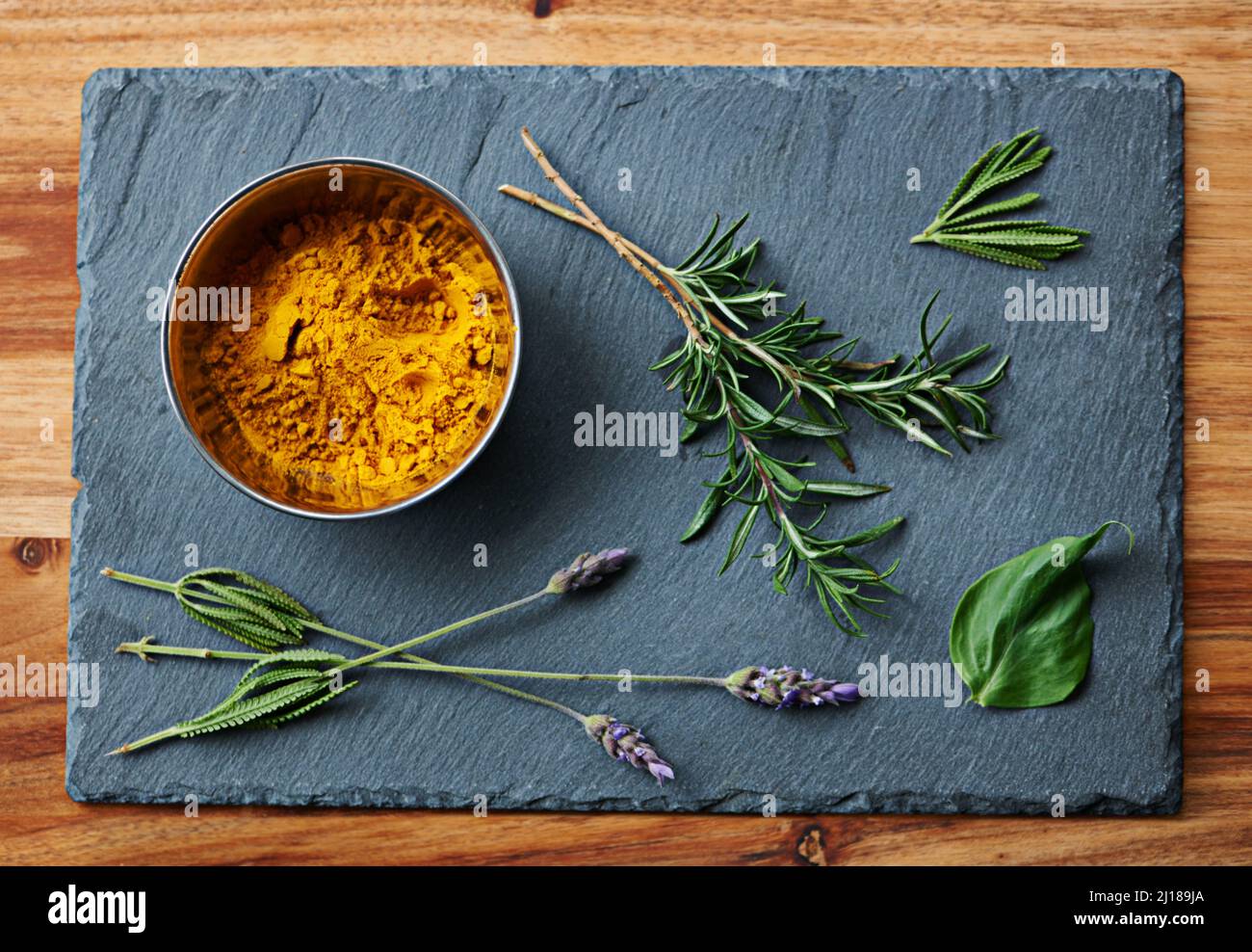 Fragrant ingredients. High angle shot of a bowl of turmeric with herbs ...