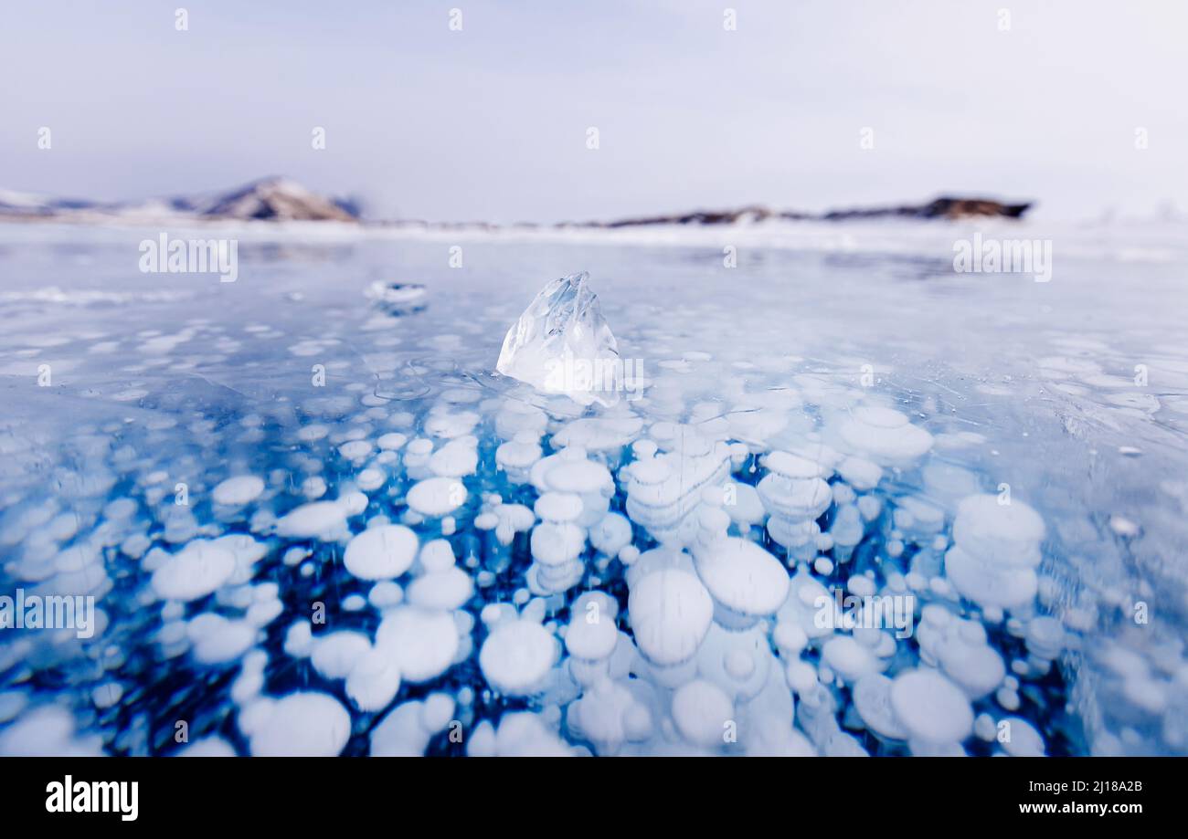Gas methane bubbles frozen in winter ice of lake Baikal, abstract ...