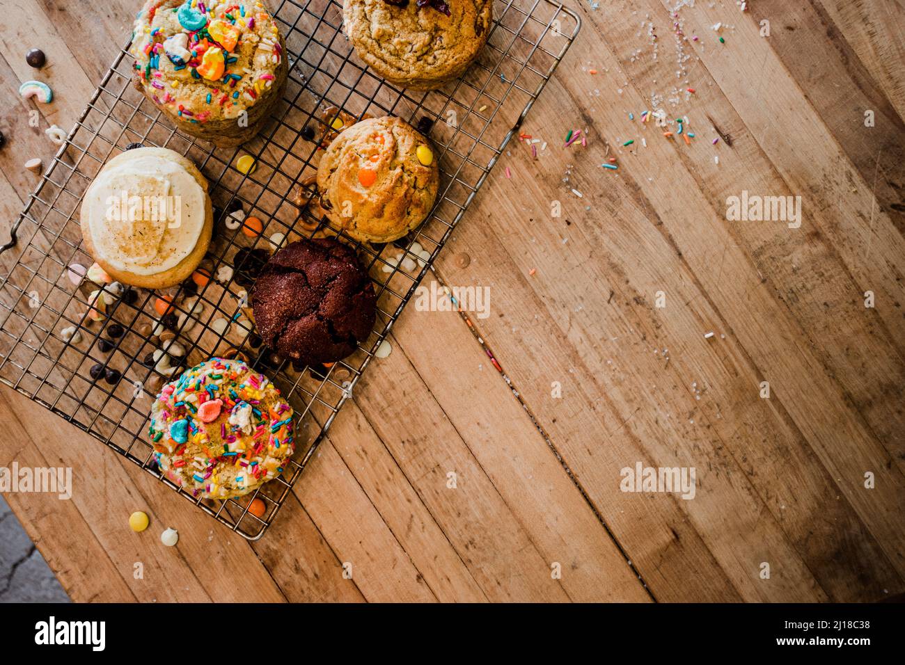 An overhead shot of freshly baked cookies cooling on a rack on a wooden ...