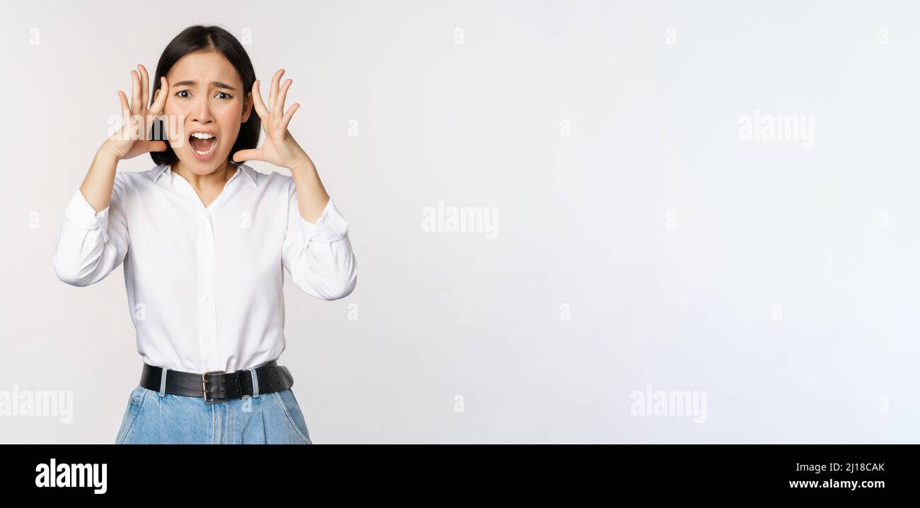 Image of shocked anxious asian woman in panic, holding hands on head ...