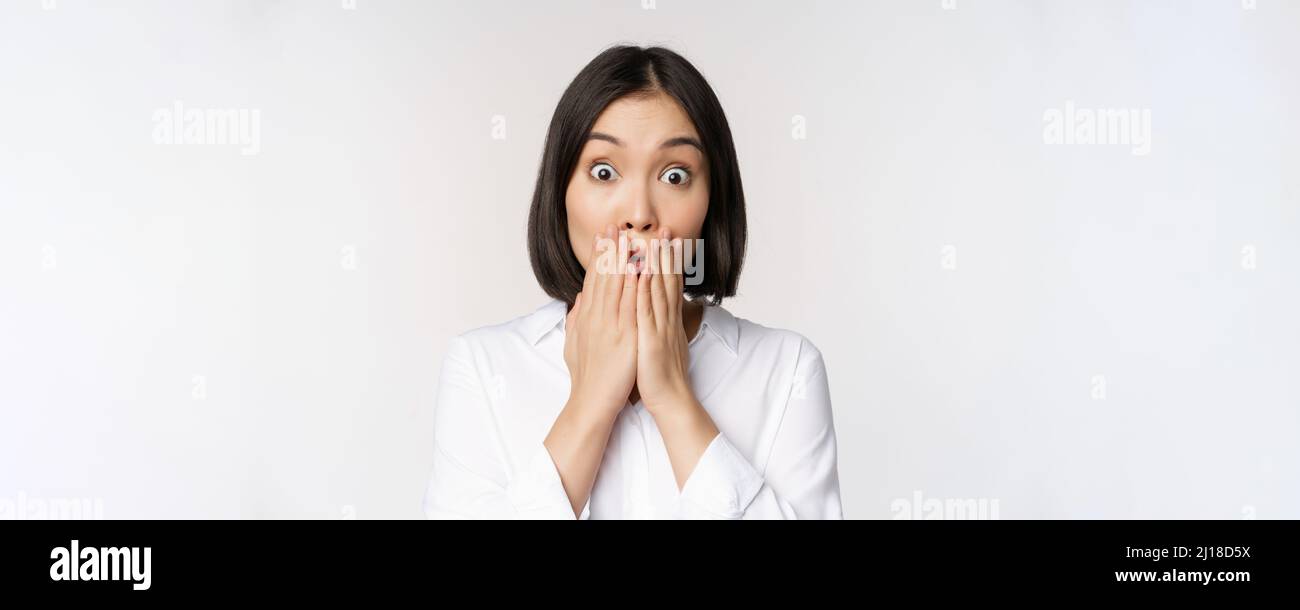 Close up face of asian woman gasping, looking shocked and speechless ...