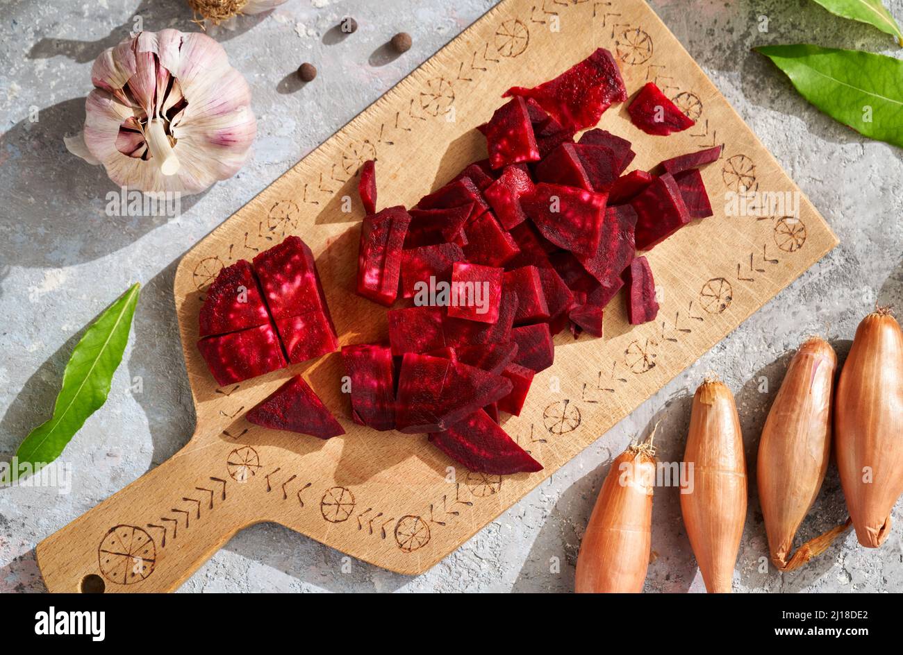 Sliced red beet on a cutting board with garlic, onion and spices ...