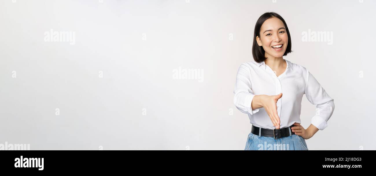 Image of confident asian woman smiling, extend hand for handshake ...