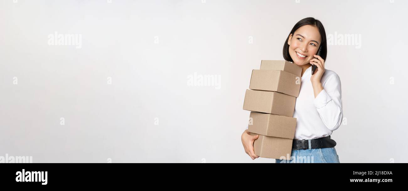 Image of young asian businesswoman answer phone call while carrying ...
