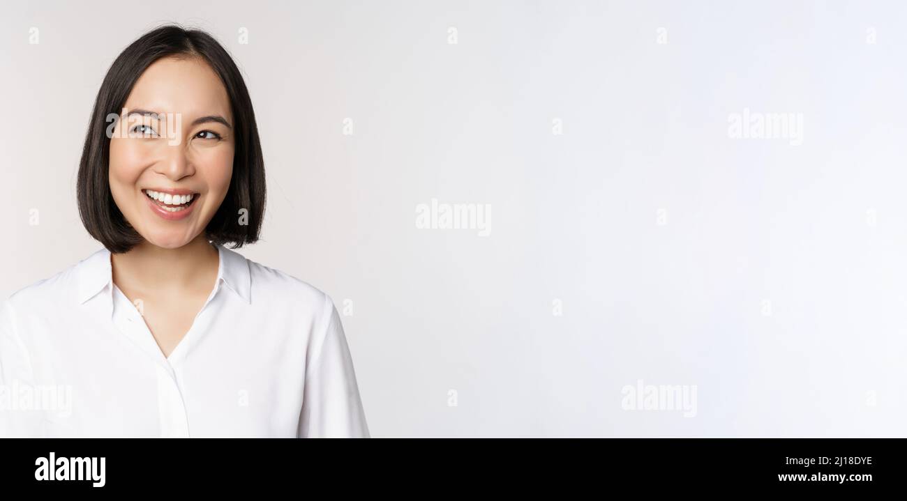 Image of smiling asian woman planning, thinking of smth, daydreaming ...