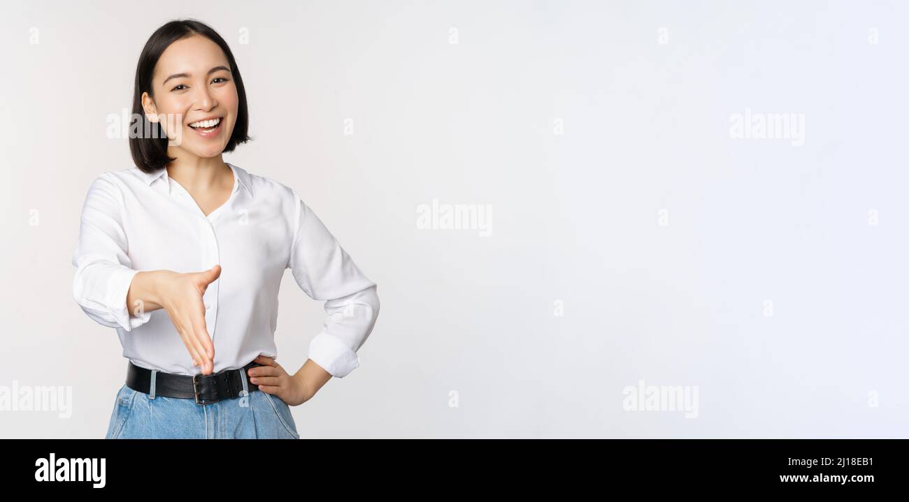 Image of confident asian woman smiling, extend hand for handshake ...