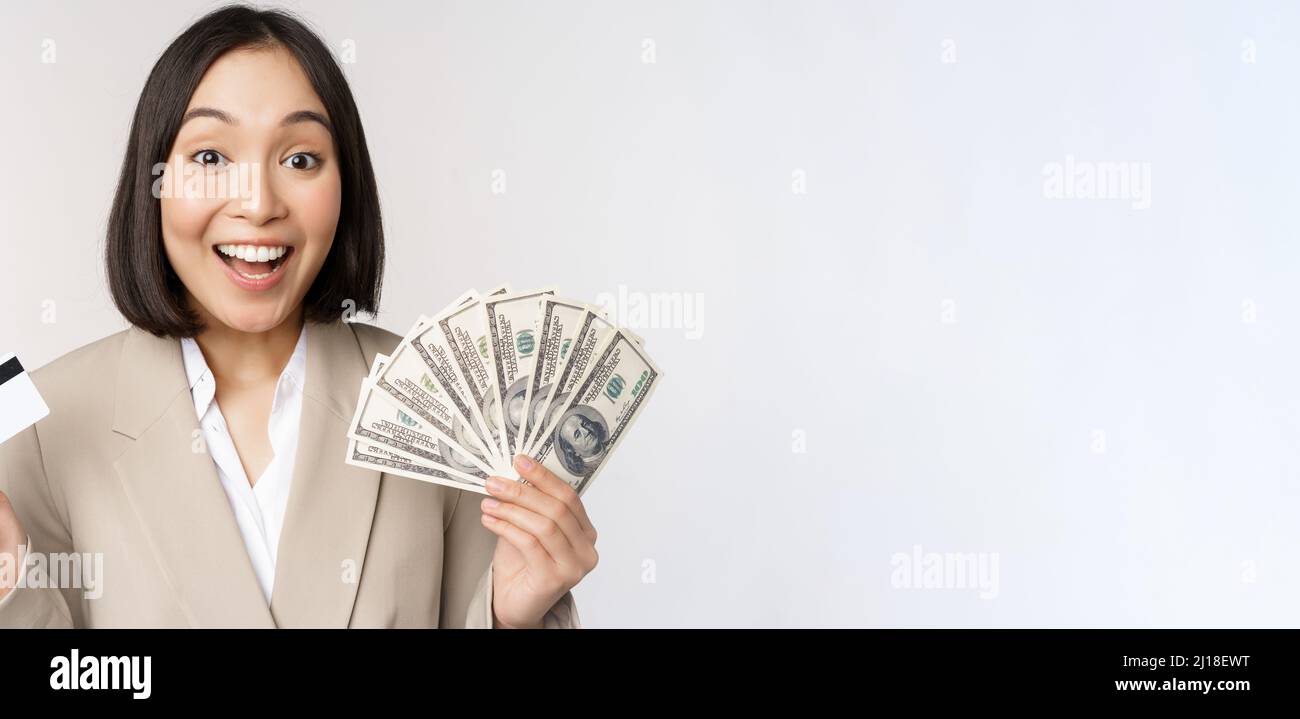 Enthusiastic young asian businesswoman, showing money dollars and ...