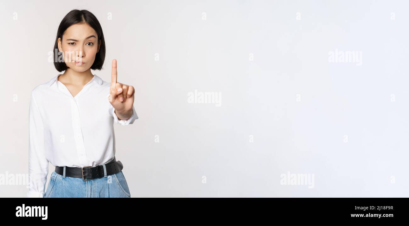 No. Young serious and confident asian woman showing stop, one finger ...