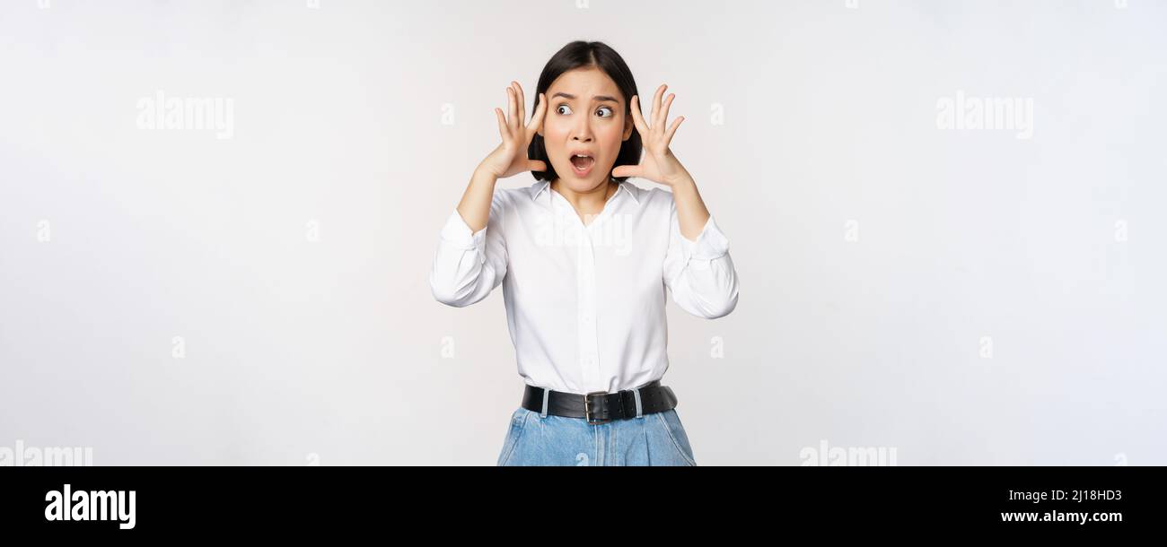 Image of shocked anxious asian woman in panic, holding hands on head ...