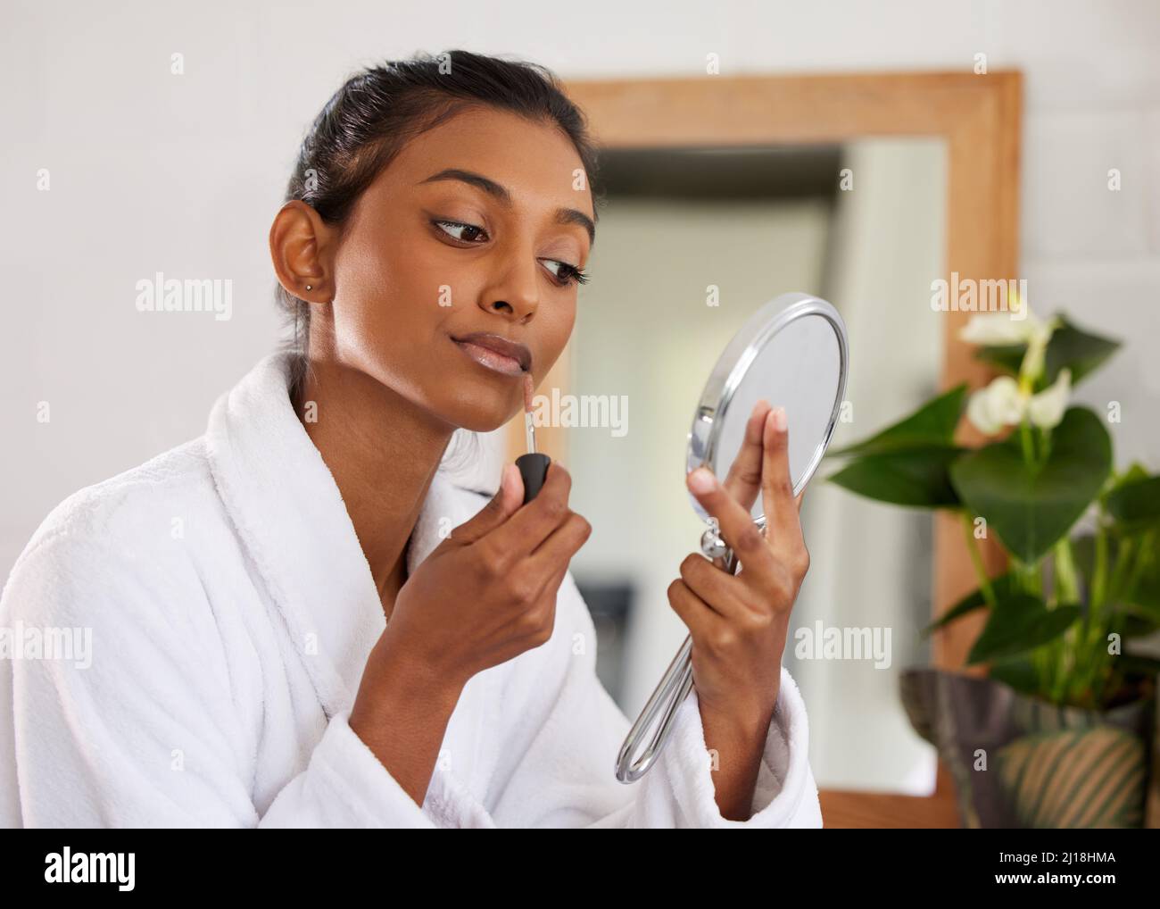 Gloss is a girls best friend. Shot of a beautiful young woman going ...