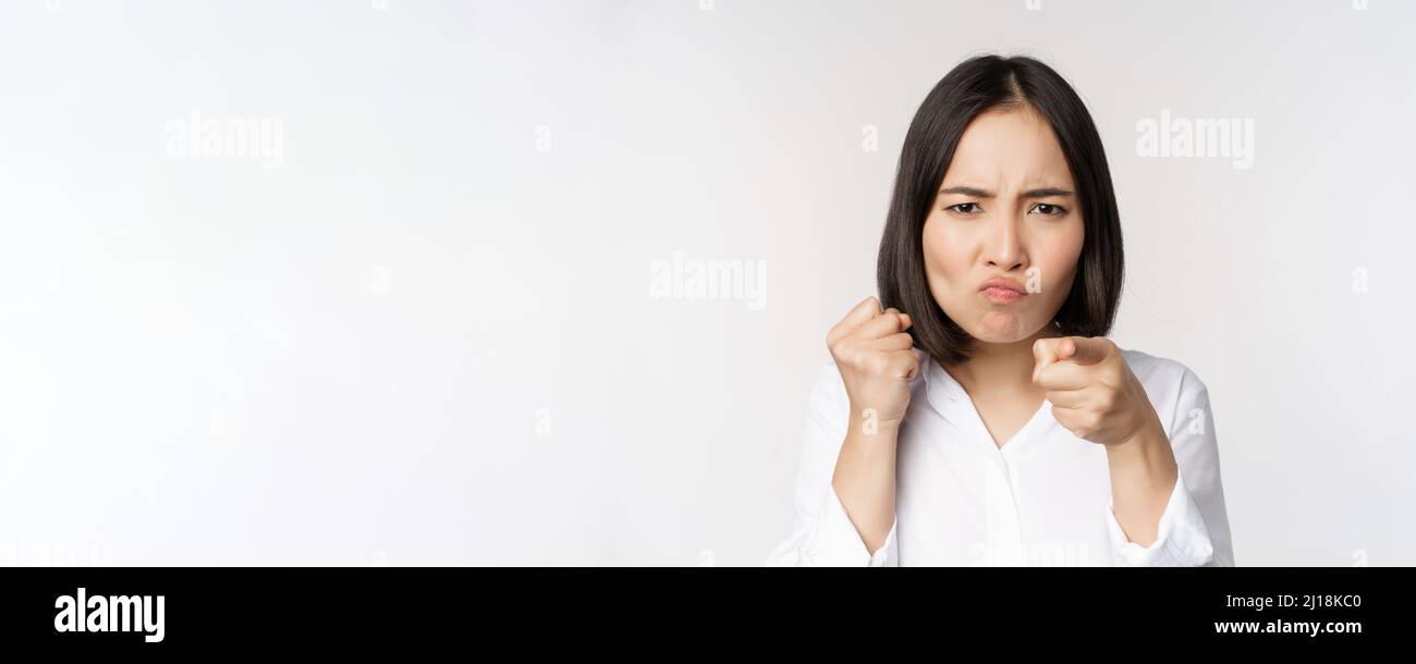 Close up of angry young woman clench fists, ready for fight, fighting ...