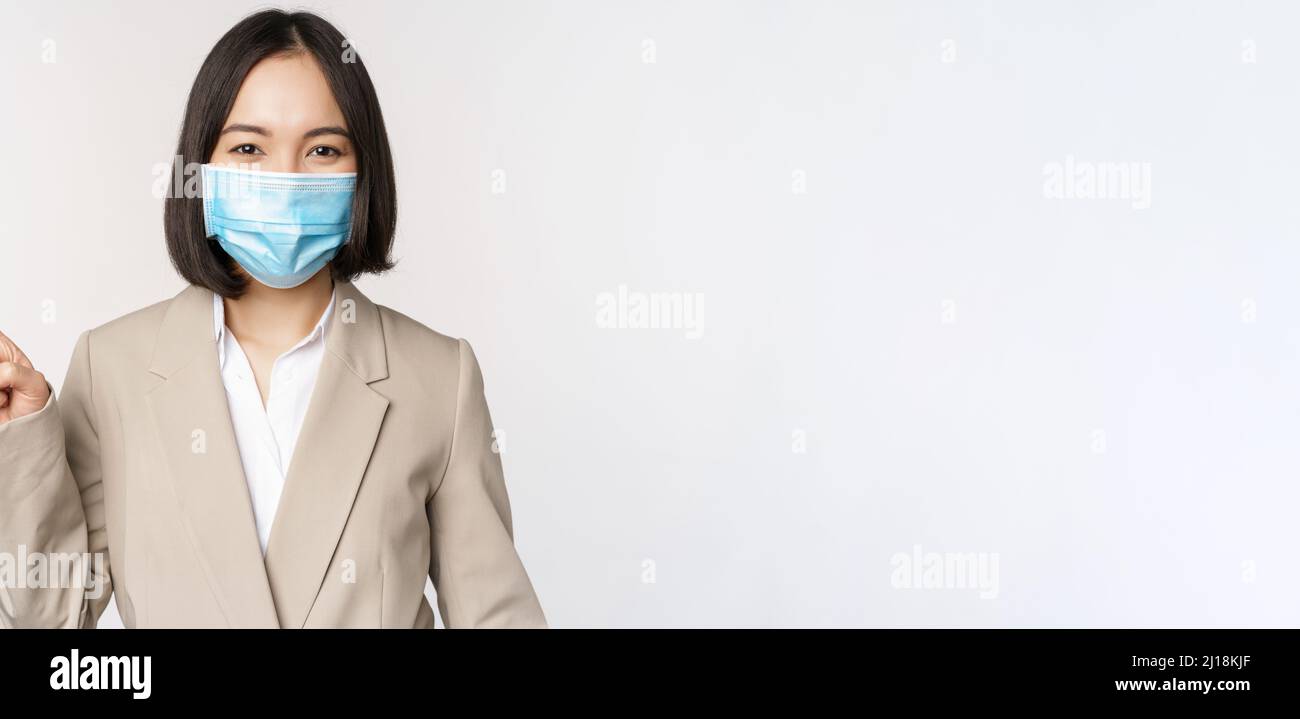 Coronavirus and work concept. Portrait of woman in medical face mask ...