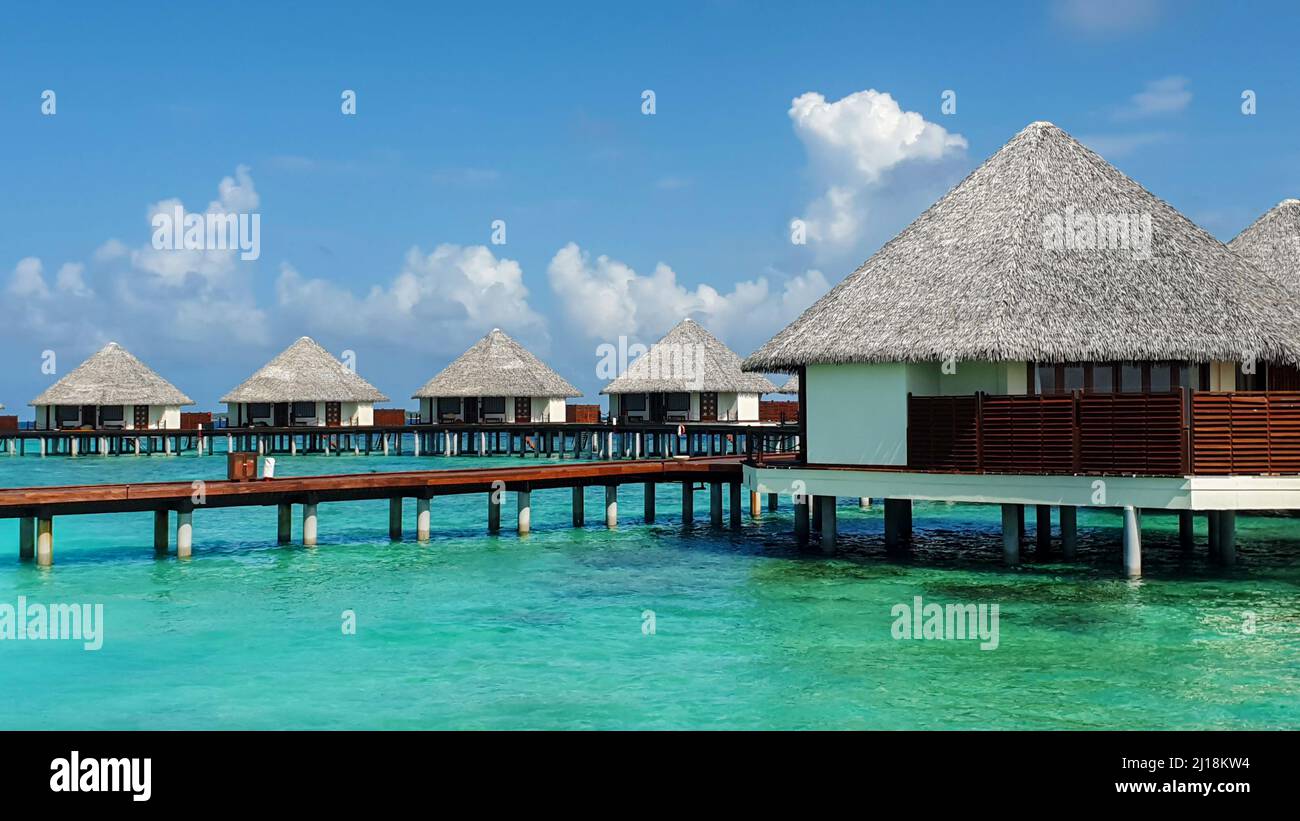 Overwater bungalows and luxury villas in the blue lagoon, on the white ...