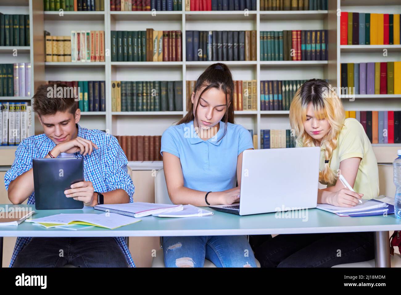 Group of teenage students studying in school library Stock Photo - Alamy