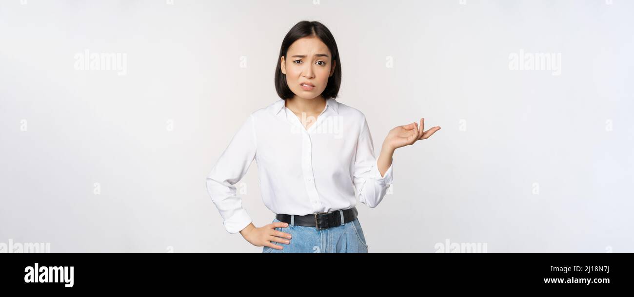 Portrait of confused asian woman asking so what, whats your problem ...